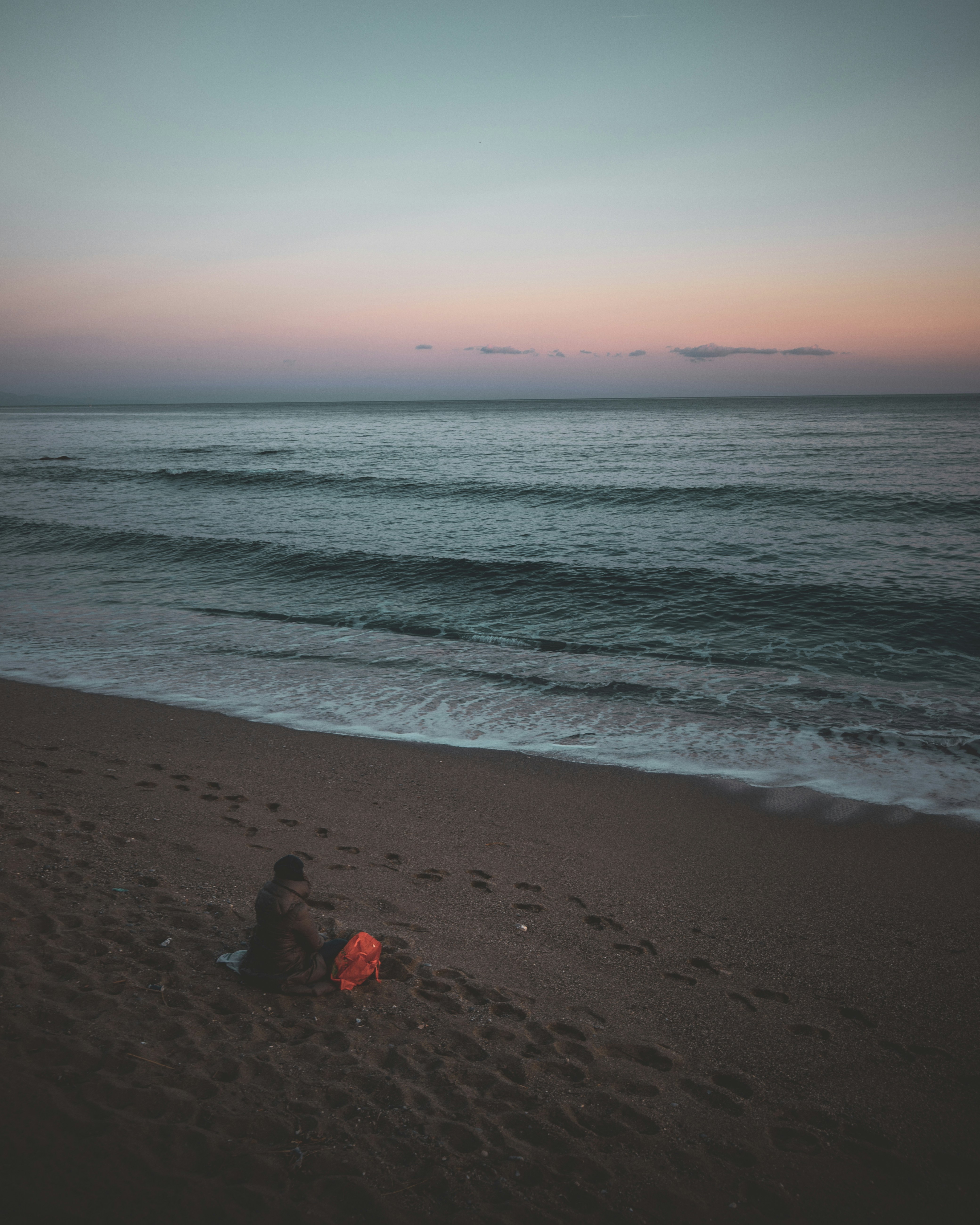 Crimson Backpack at Dusk: A Quiet Shoreline Moment