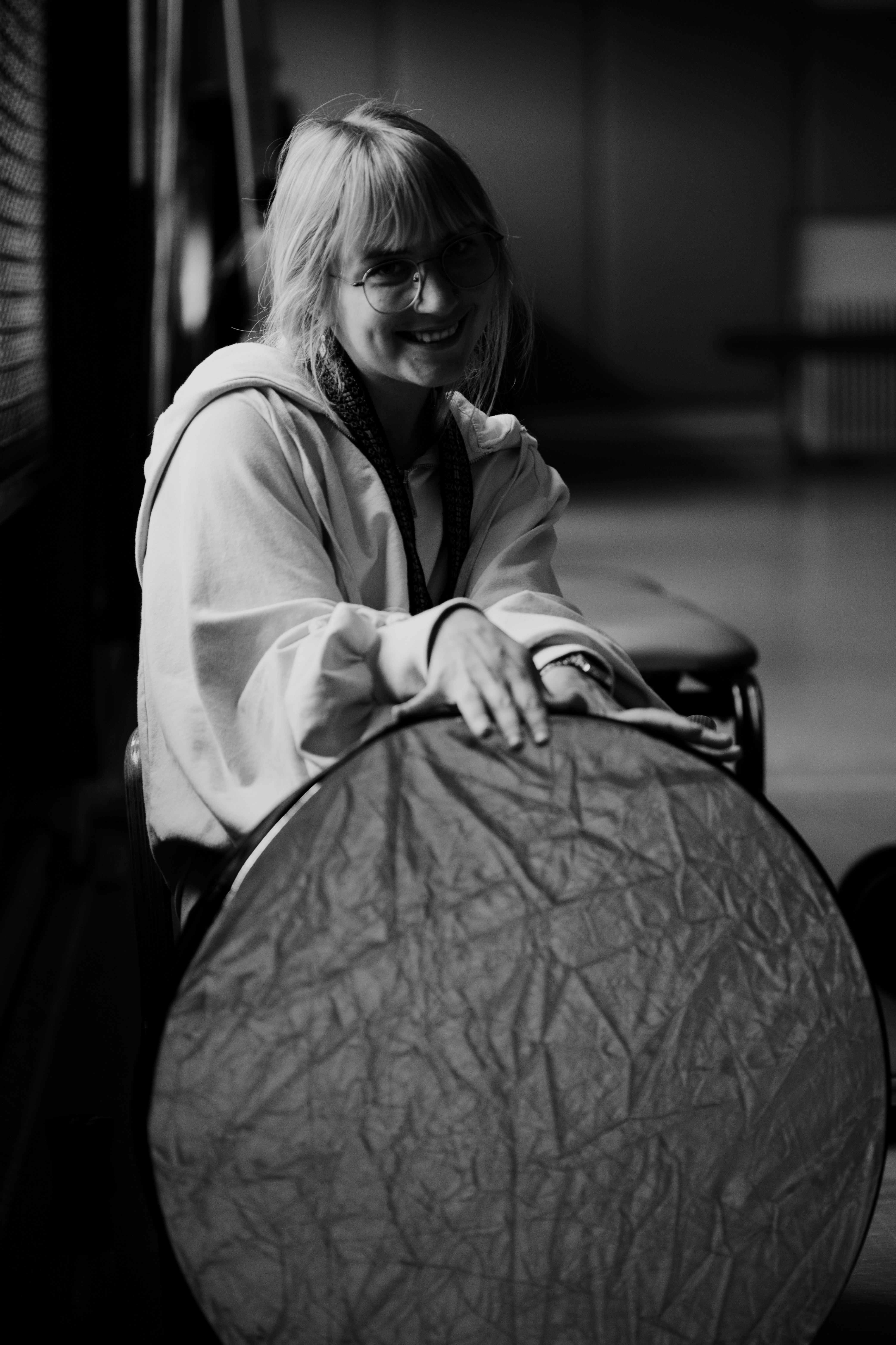 Soft Grin Under Studio Light: A Grayscale Portrait with a Reflector
