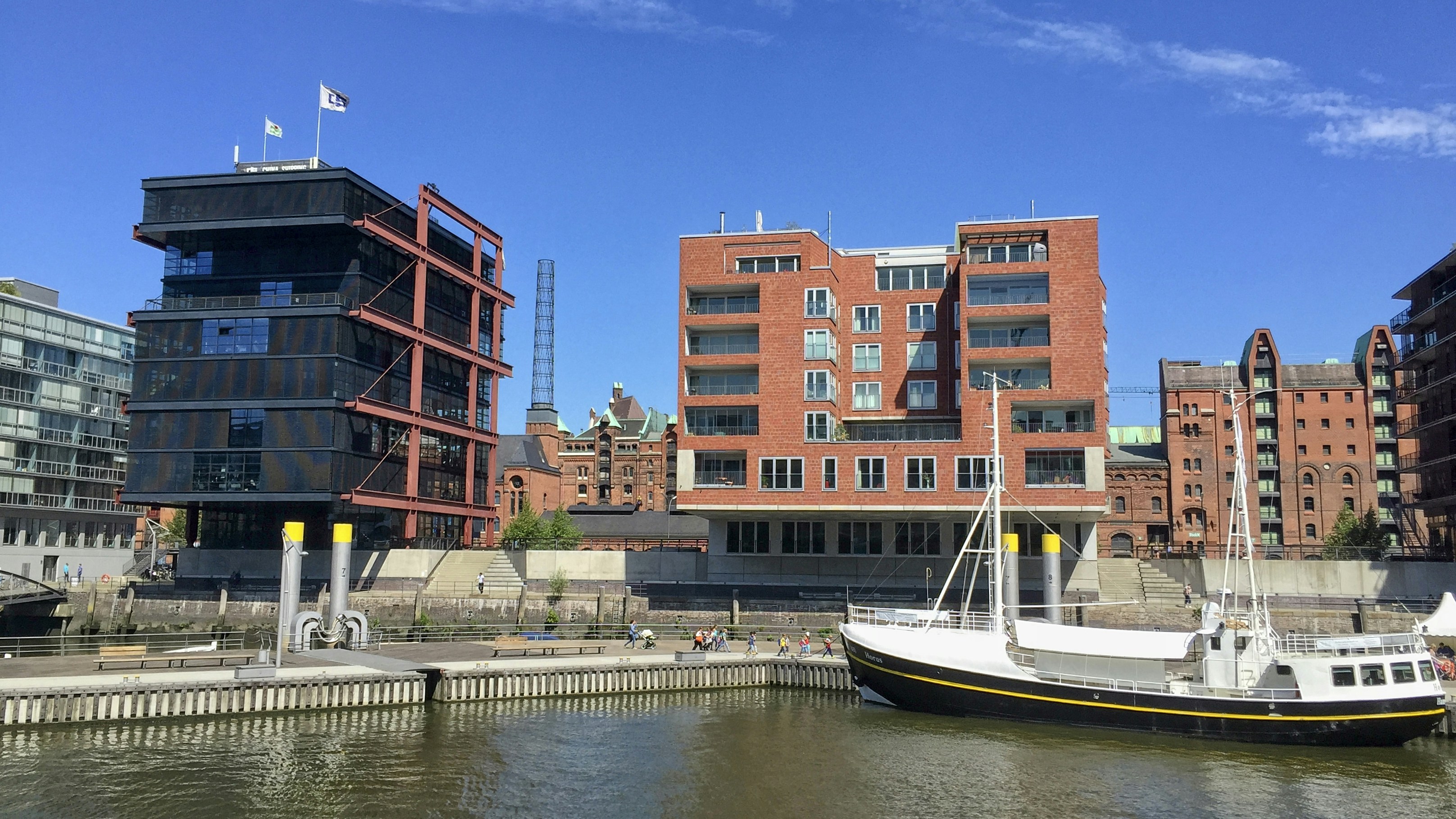Foto Barco blanco y azul en el muelle cerca de un edificio de hormigón marrón durante el día ...