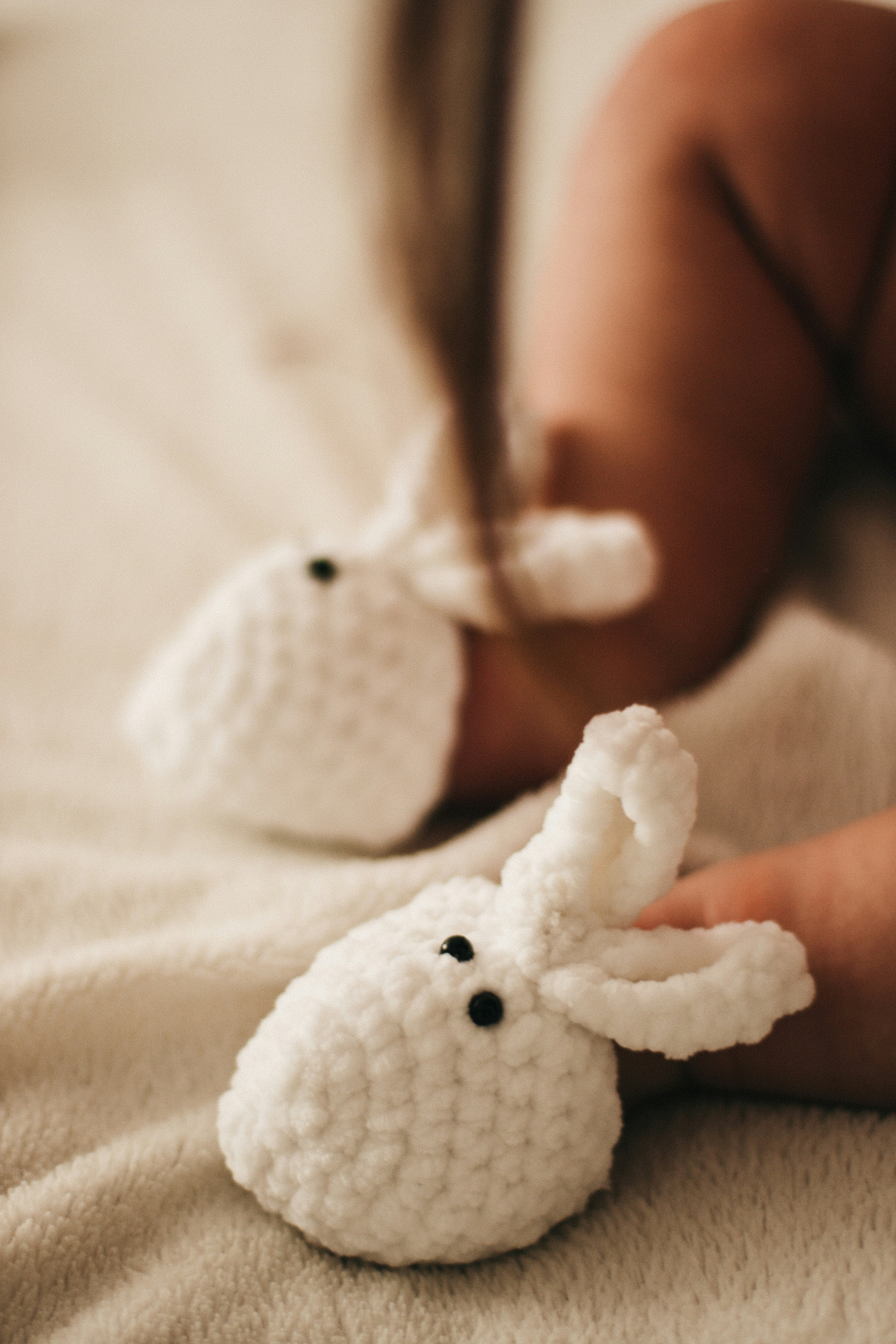 Cotton-tufted friends: tiny bunnies at rest on a cozy blanket