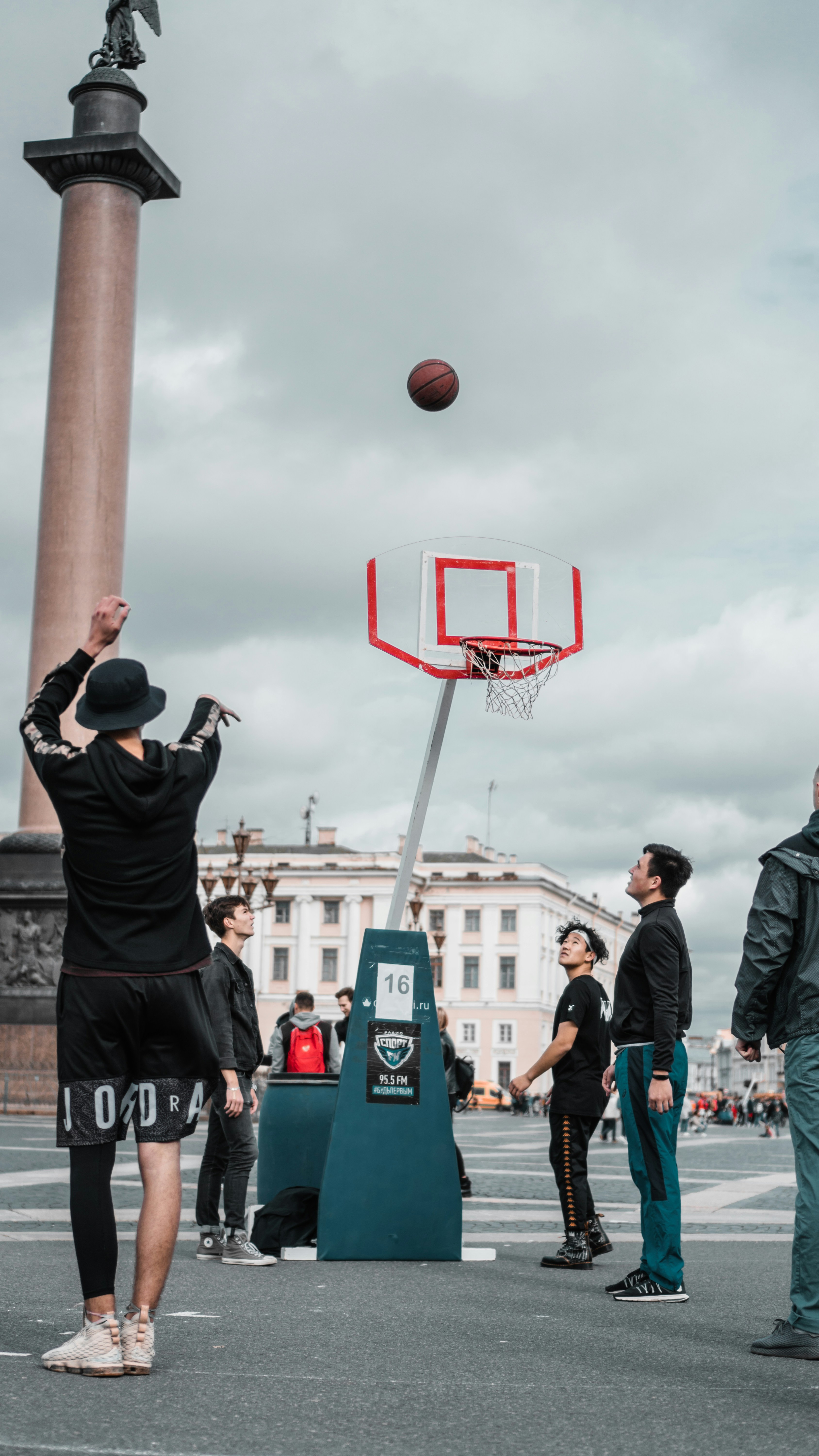 Midair Arc Over a Classical City Square Basketball Hoop