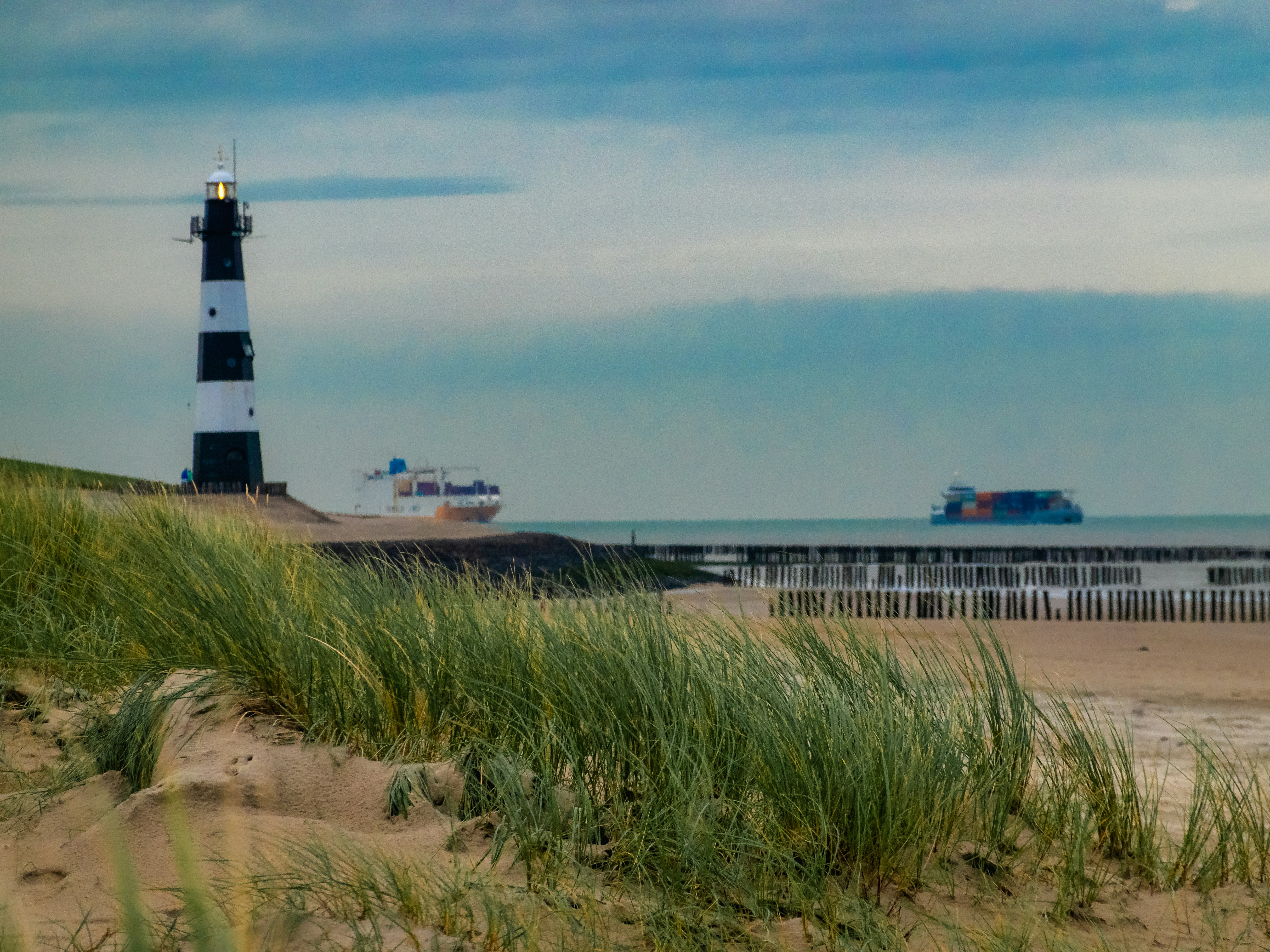 white and black lighthouse near body of water during daytime