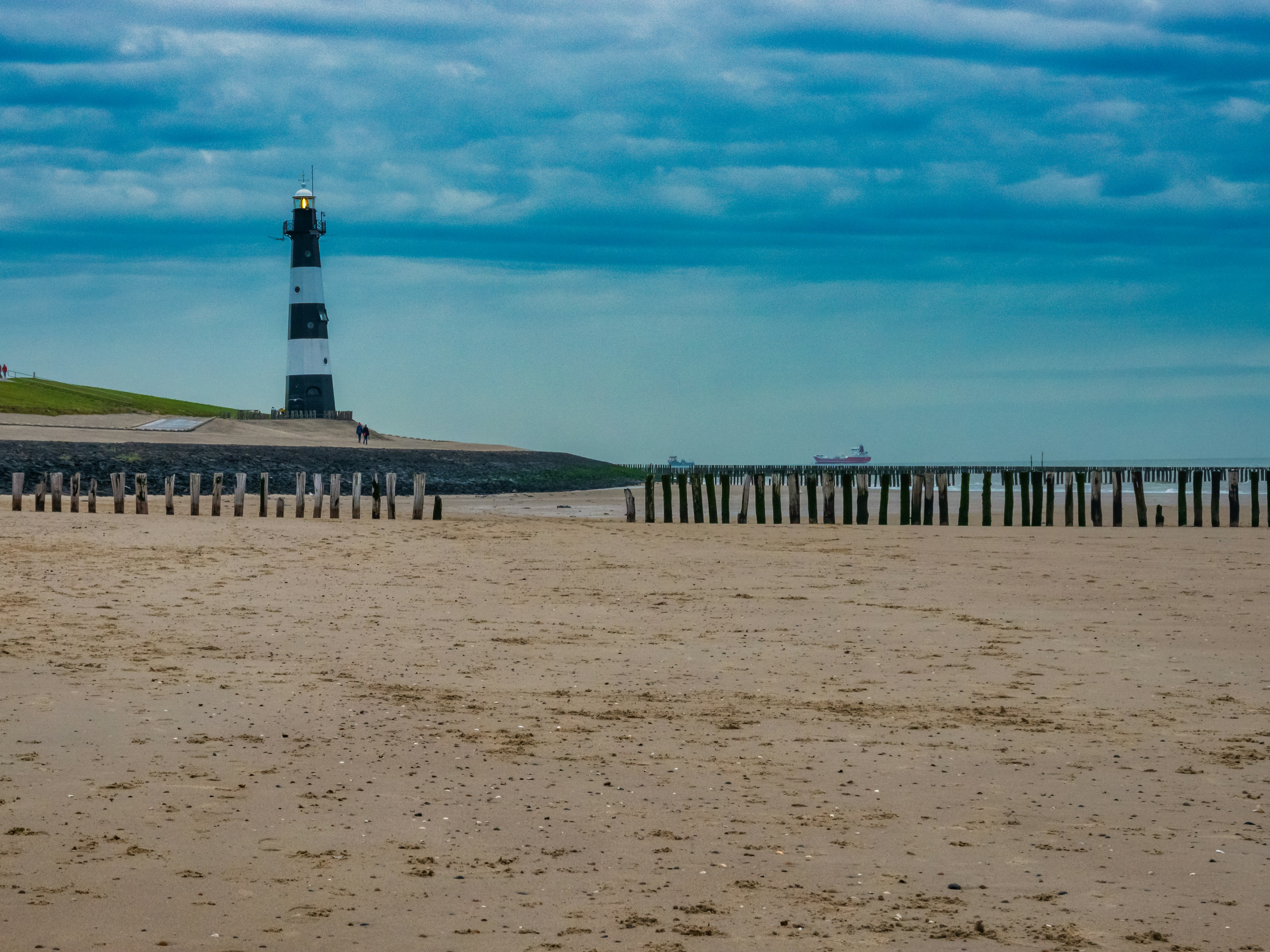 Beacon at the Boundary: Lighthouse, Pier Posts, and a Sea-Blue Horizon