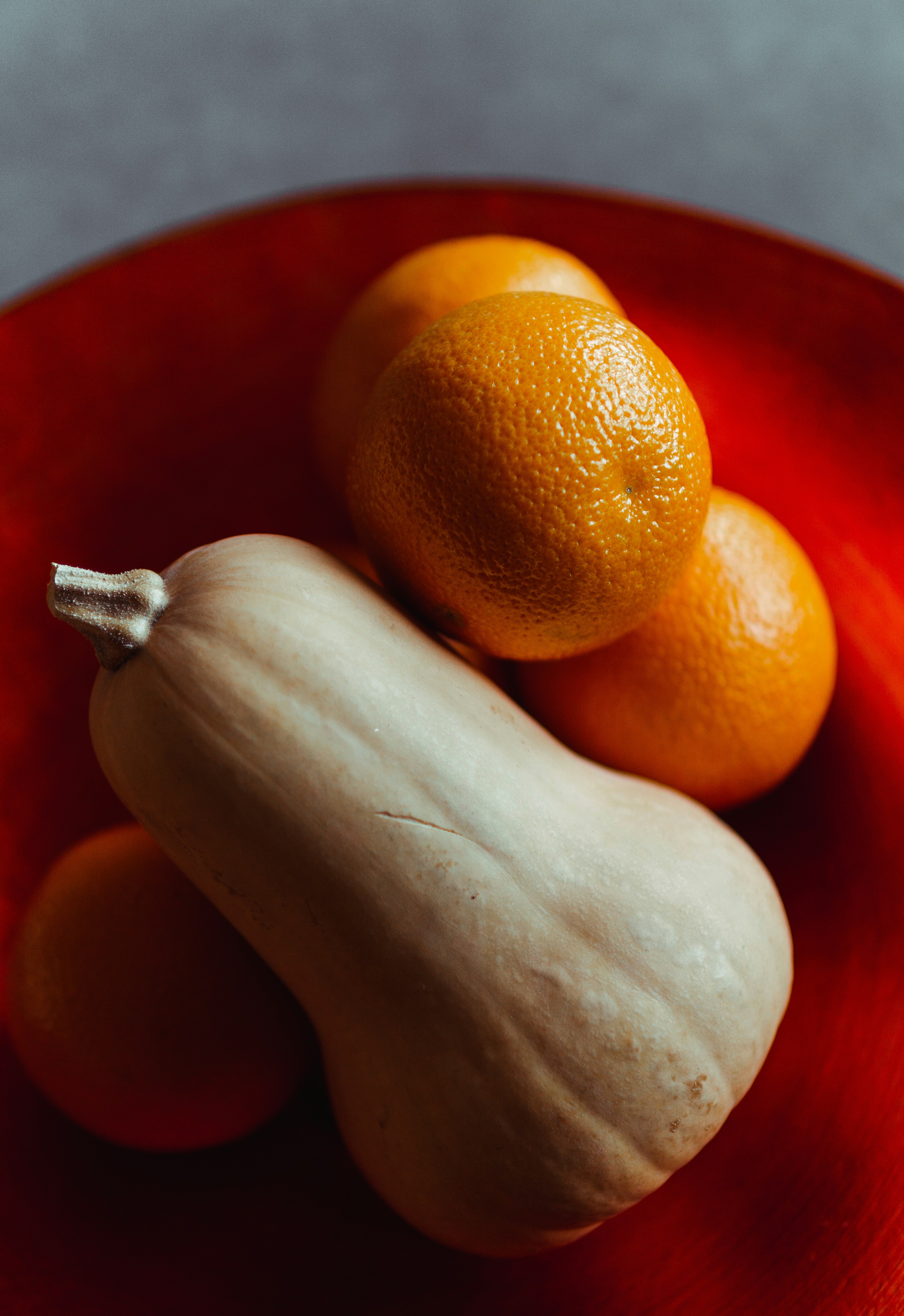 Funny shaped pumpkin in a bowl of oranges