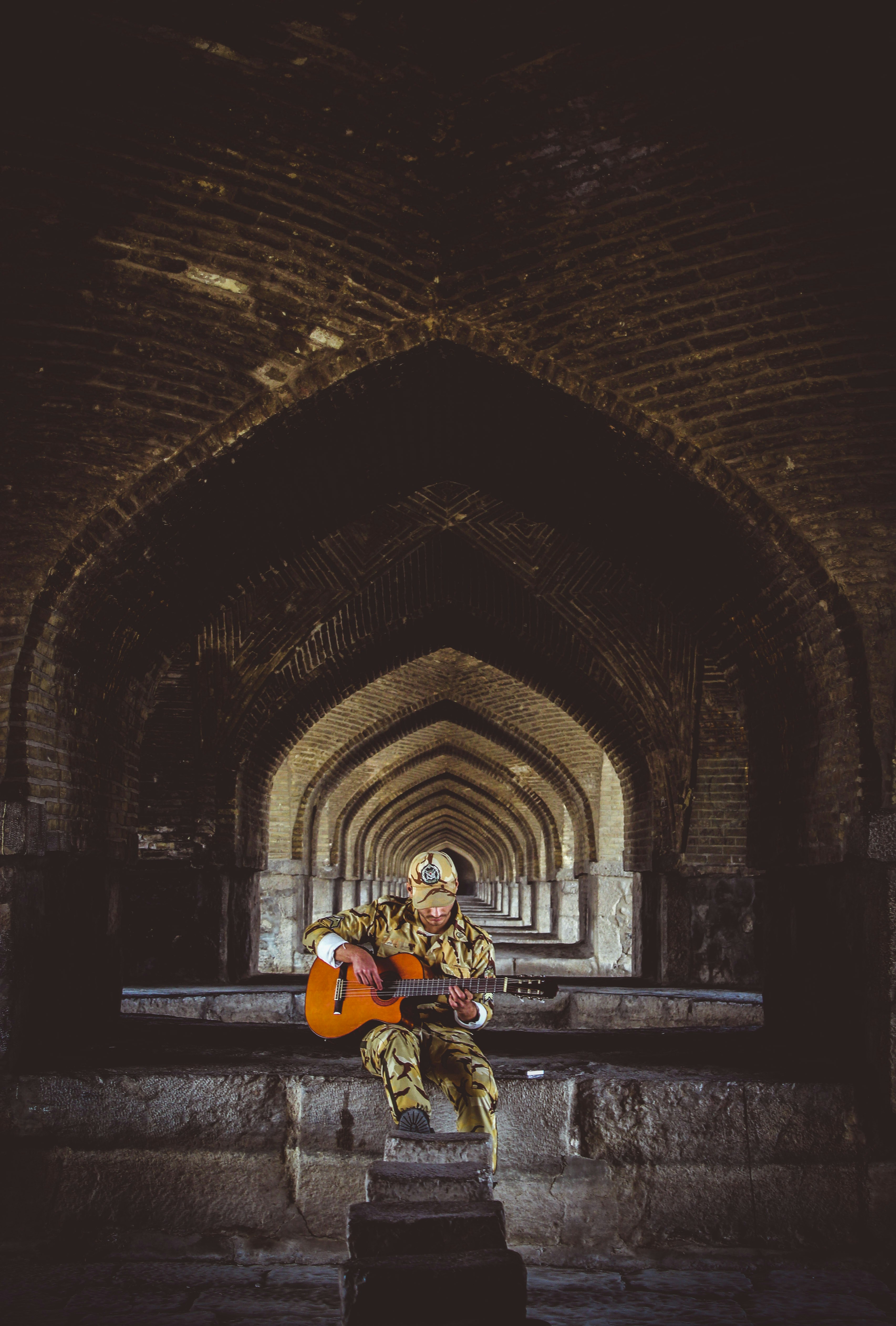 Guitar in the Archway: A Soldier’s Serenade Amid Ancient Arches