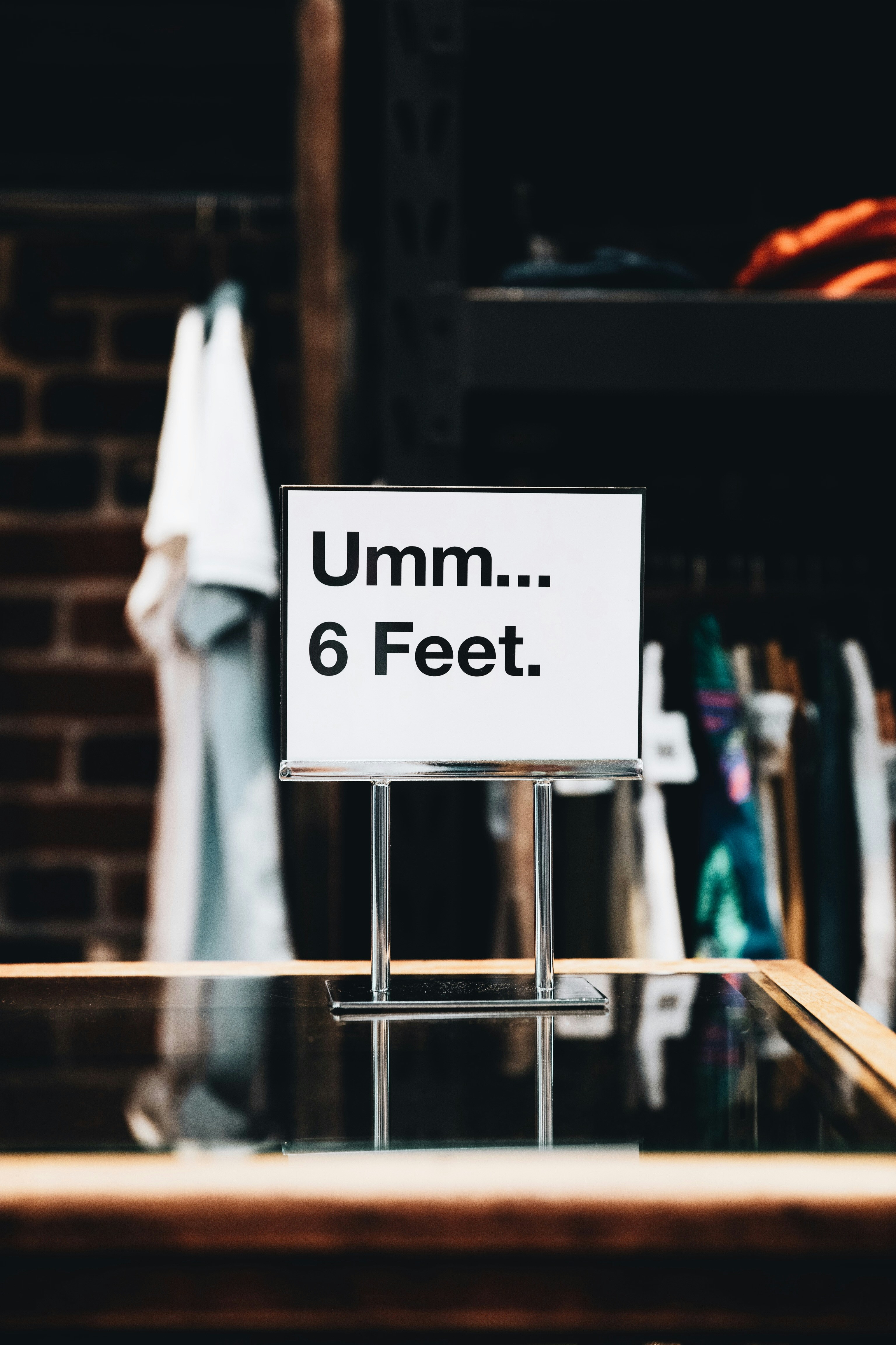 Six Feet of Distance: A Sign Anchoring a Quiet Wardrobe Scene
