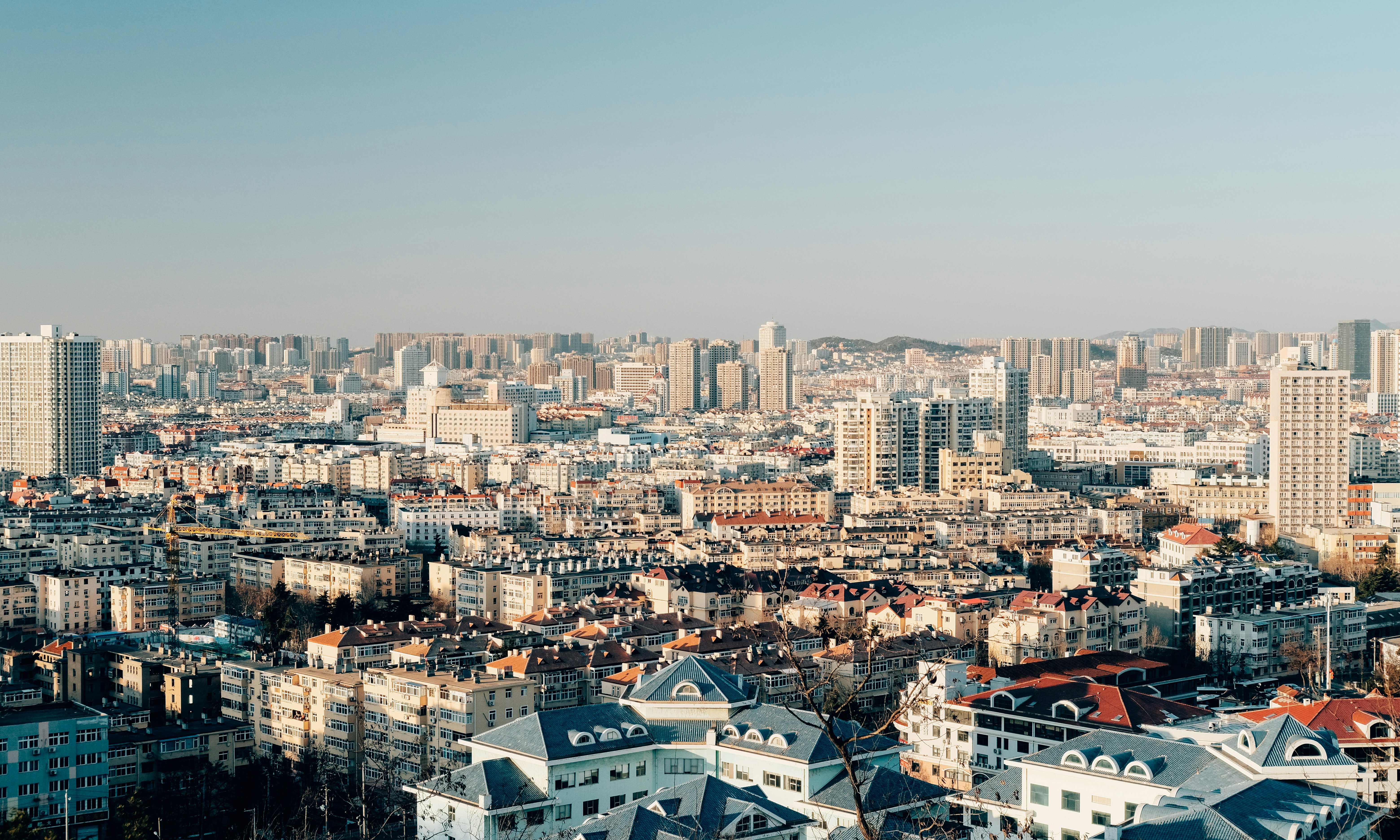 Expansive cityscape with diverse buildings under a clear blue sky.