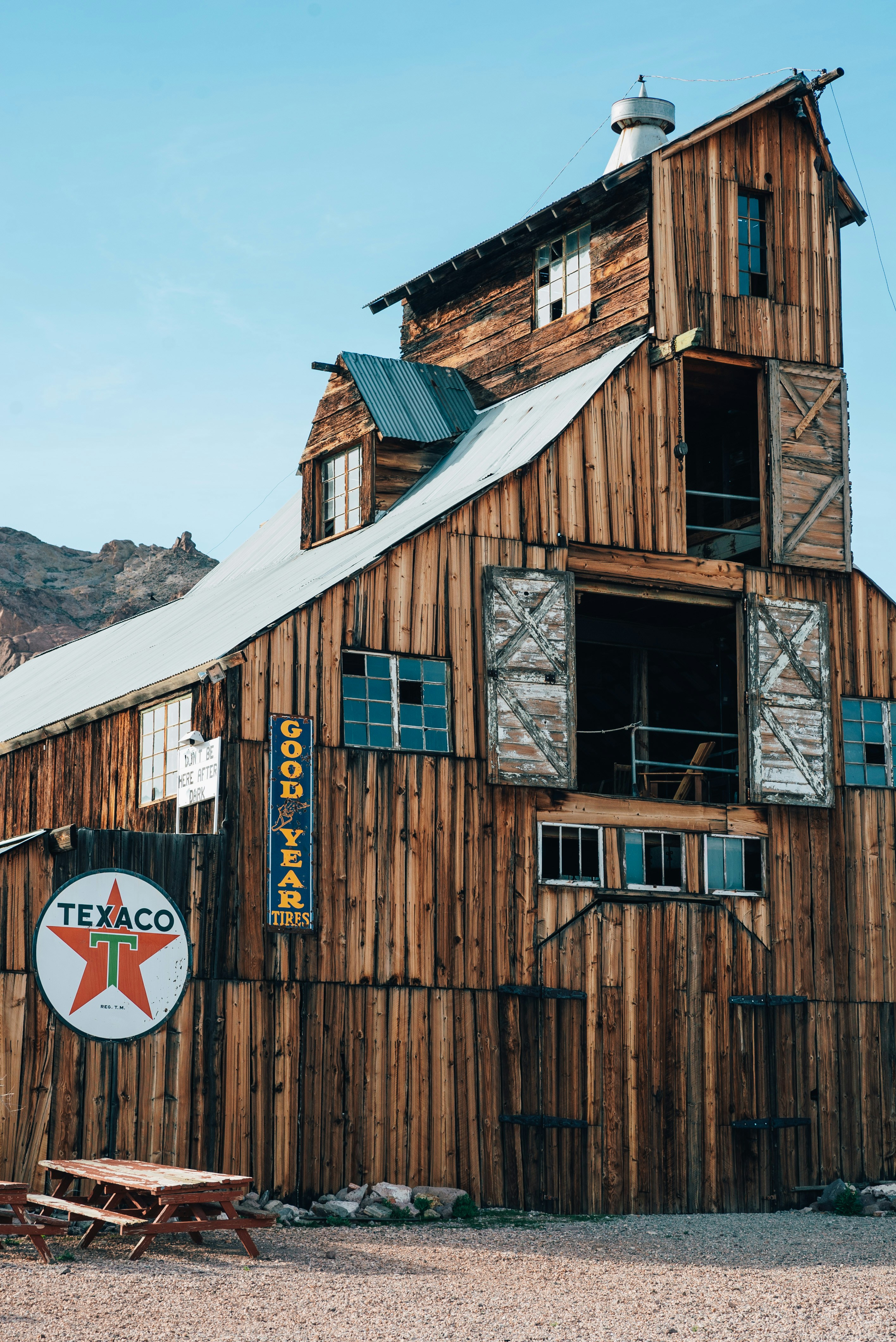 Weathered Timber Facade with Vintage Texaco Sign Under a Clear Desert Sky