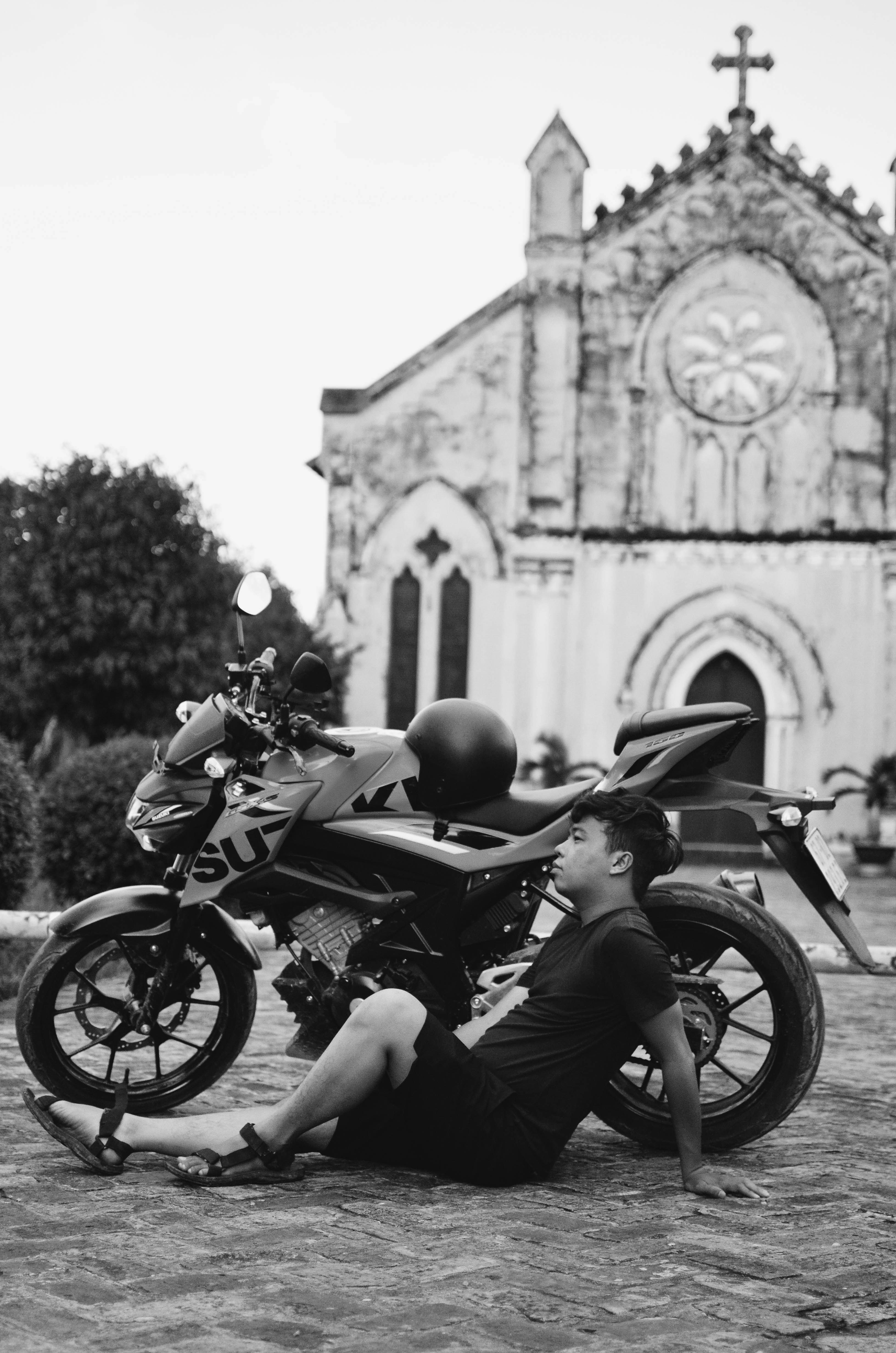 Paused by Stone and Steel: A Rider’s Quiet Portrait Before the Chapel
