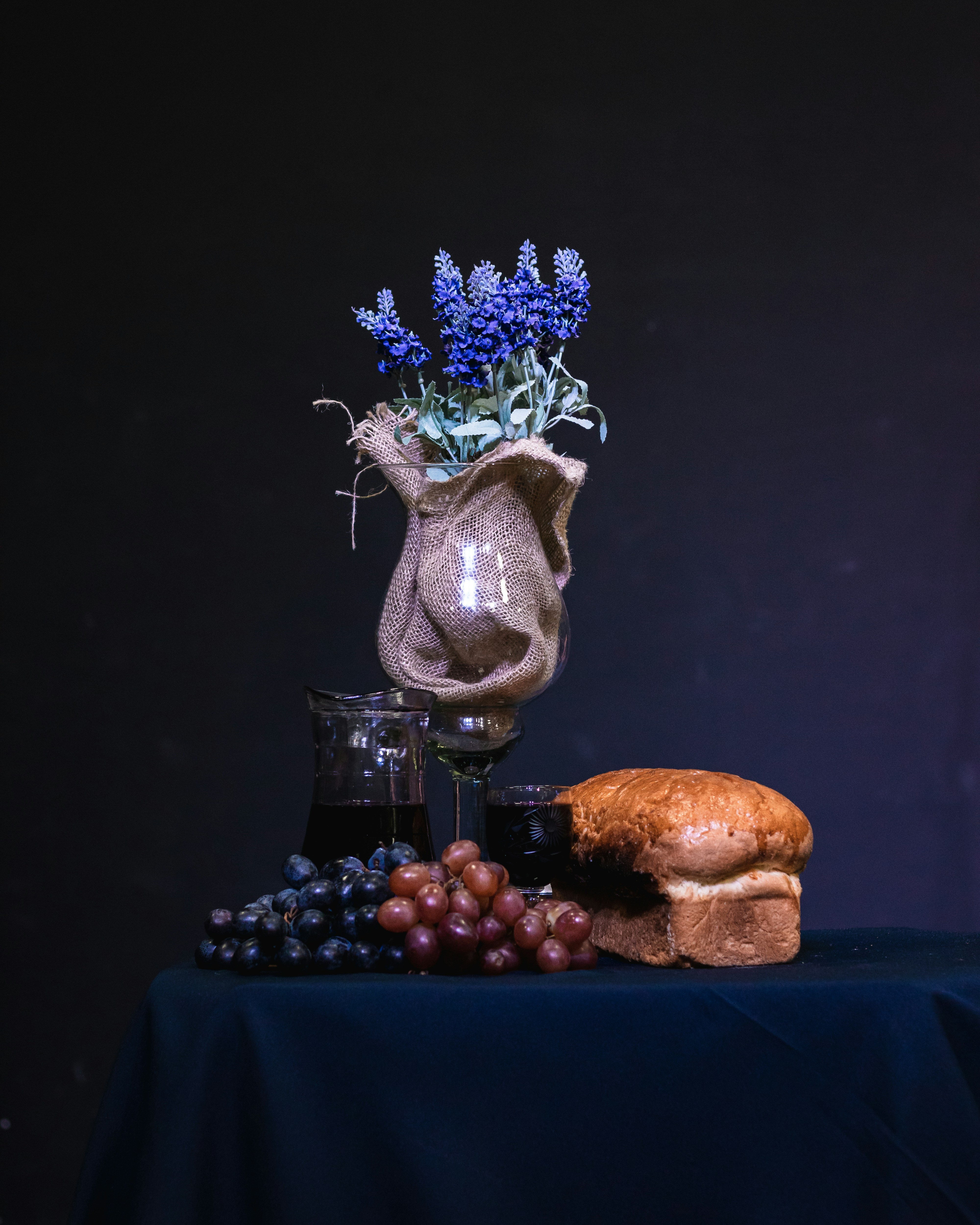 Lavender in Burlap: A Rustic Still-Life Anchored by Grapes and Bread