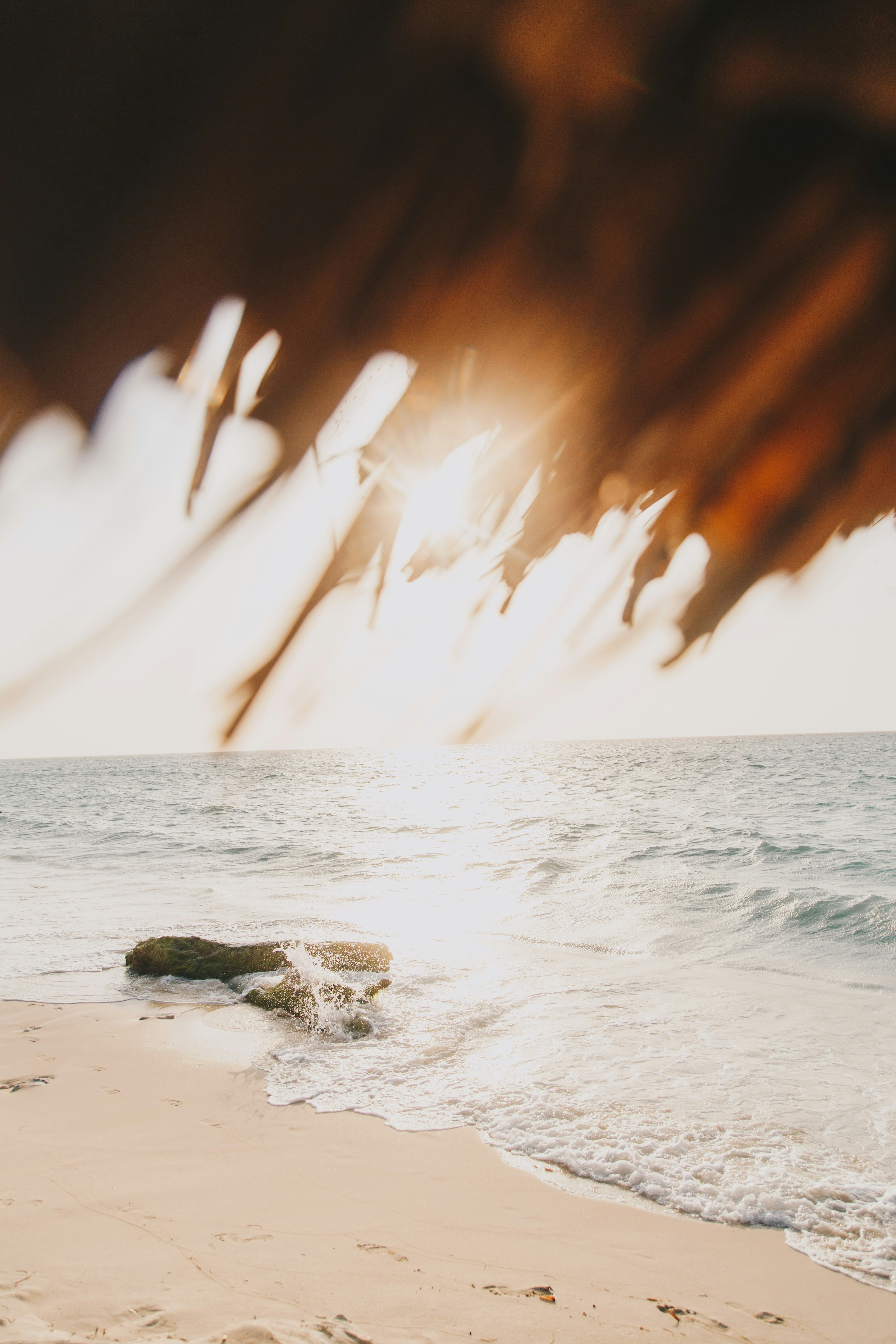 Sunburst at the Shore: Fire-Tinted Sky Fractures a Tranquil Beach