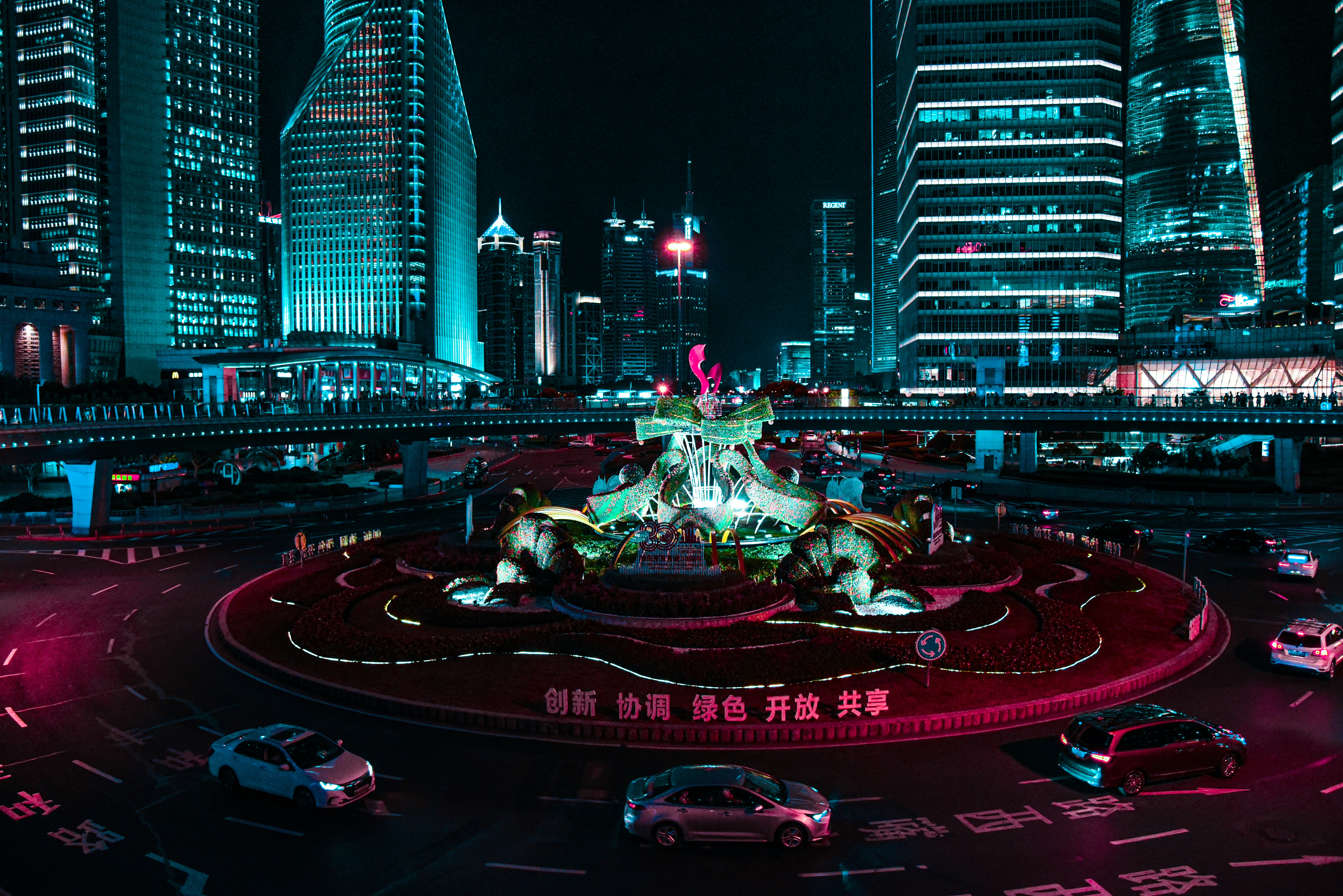 Neon Circle: Night city sculpture under a turquoise skyline