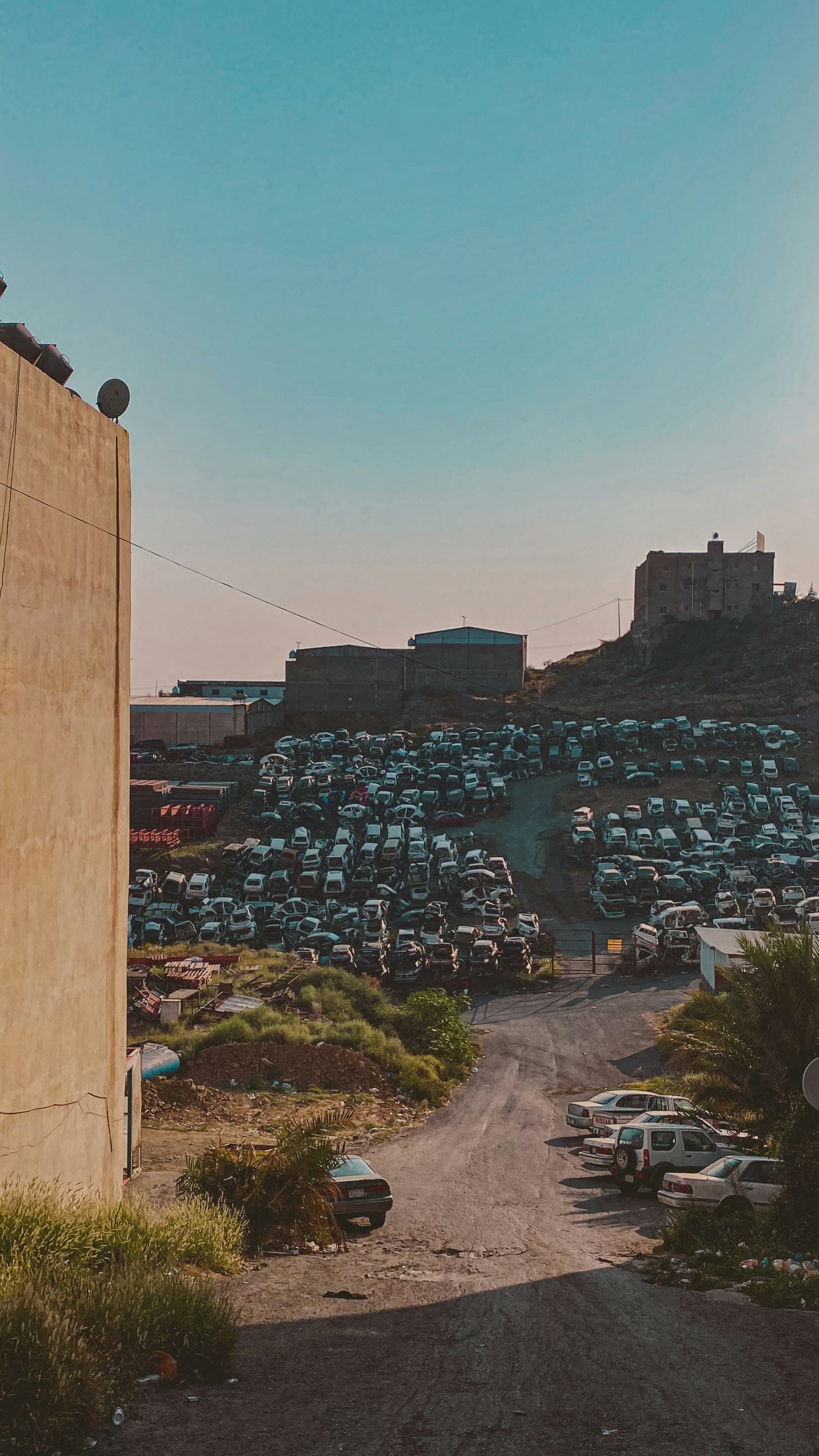 Sunlit Parking Sea beneath a Narrow Urban Cliff