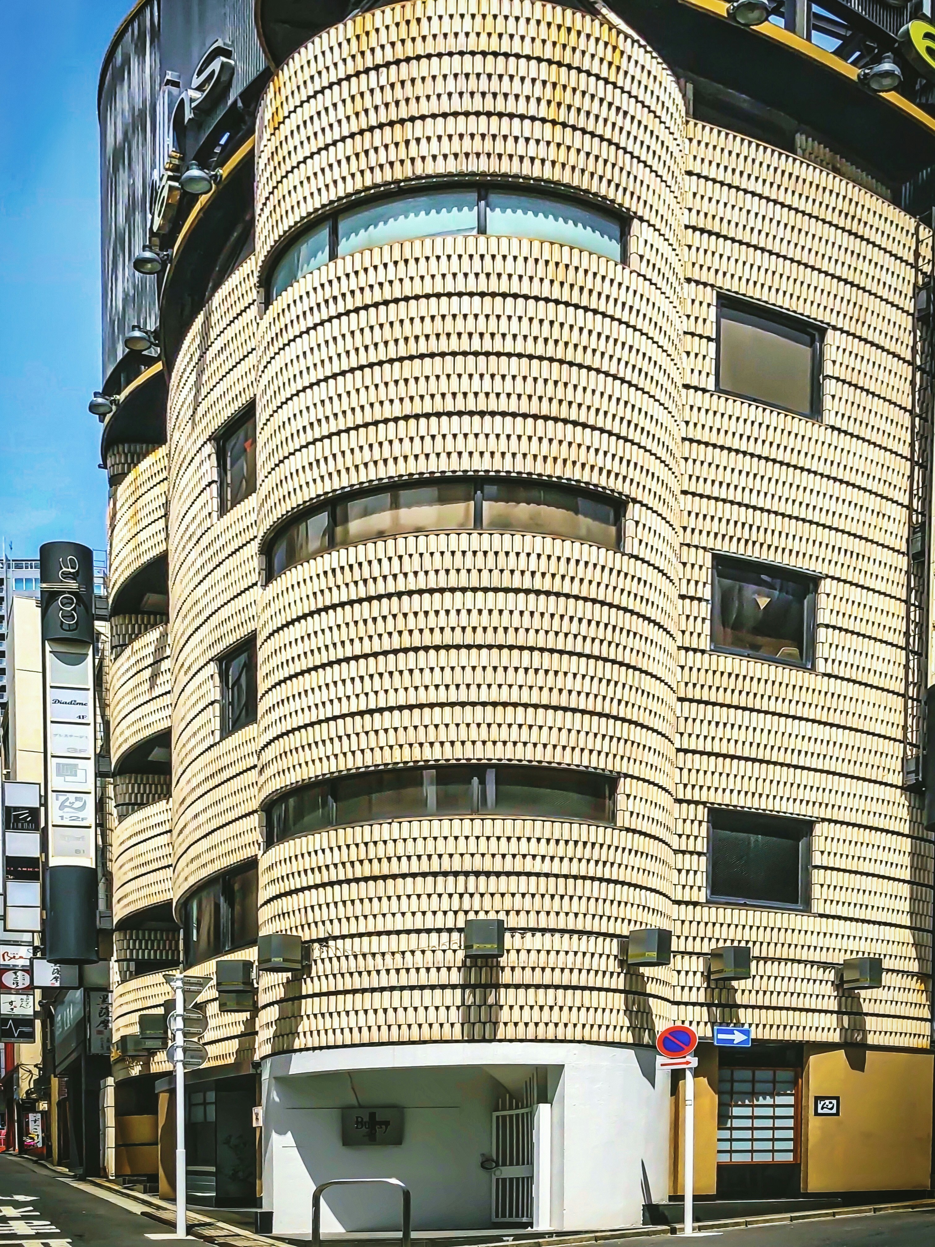 Sunlit Cylinder: A Curved Brick Facade Wrapping a Narrow Street