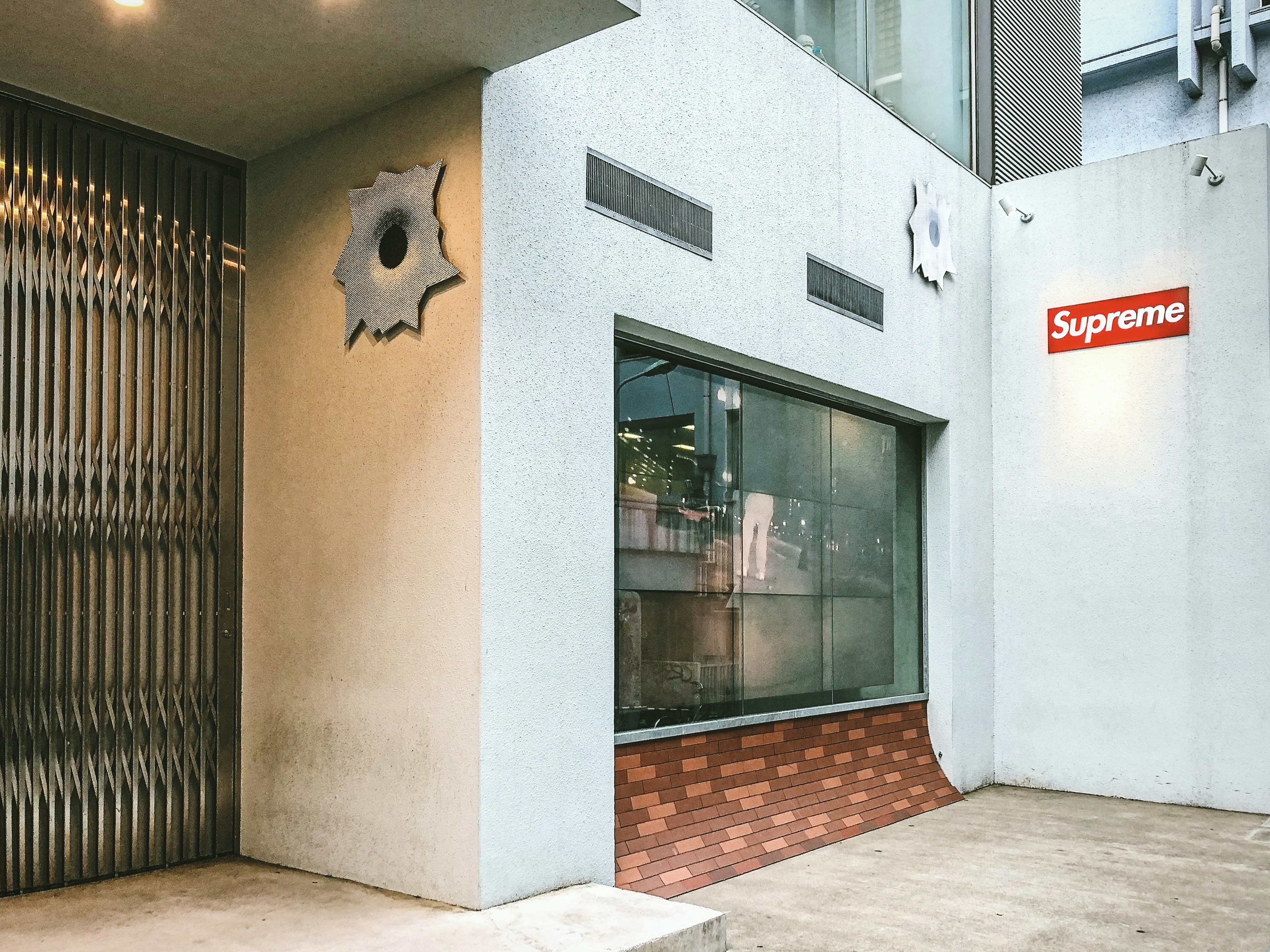 Shattered Wall, Window Display, and a Red Supreme Sign: A Quiet Urban Portrait