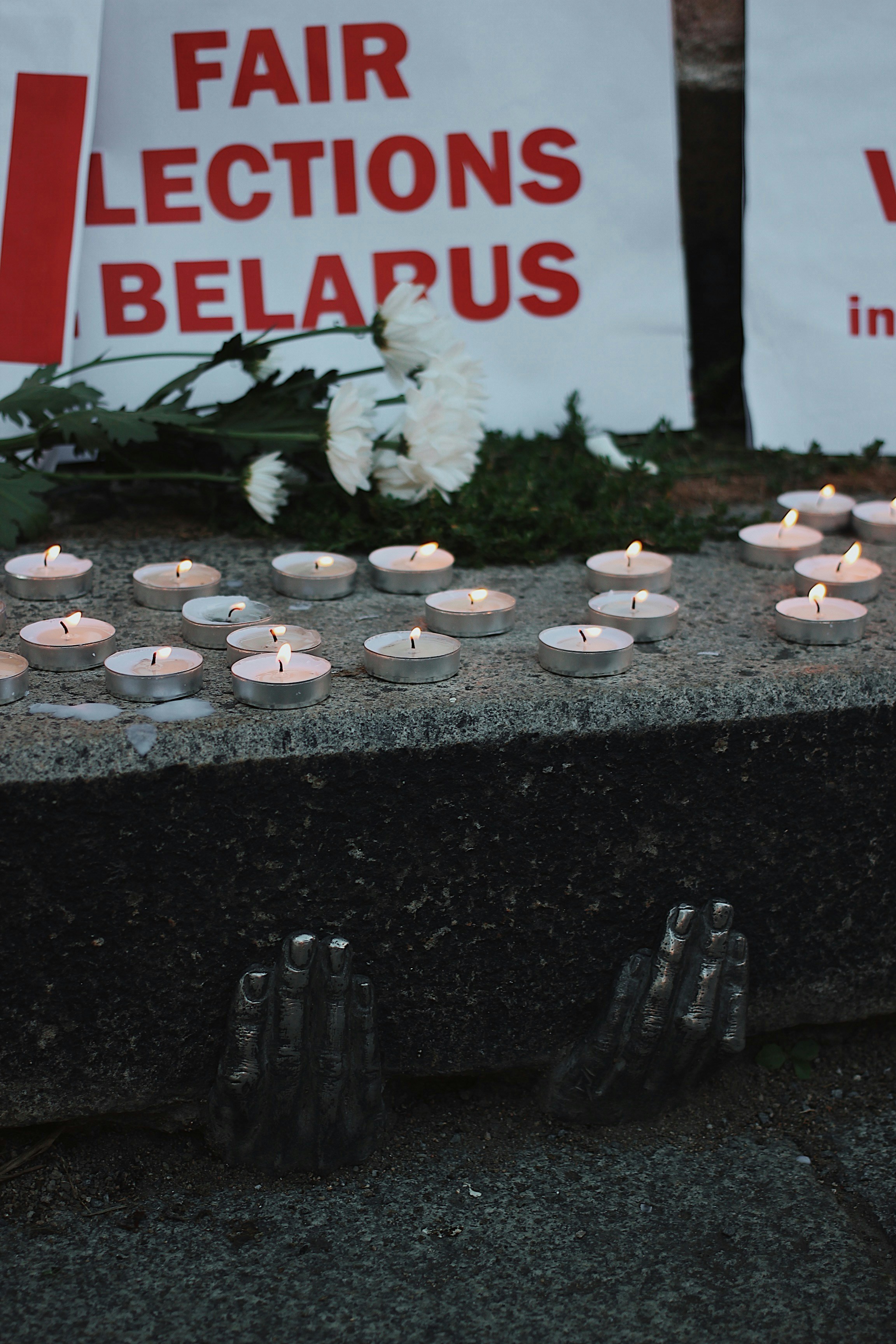 Candlelit Memorial Beneath a Belarus Banner
