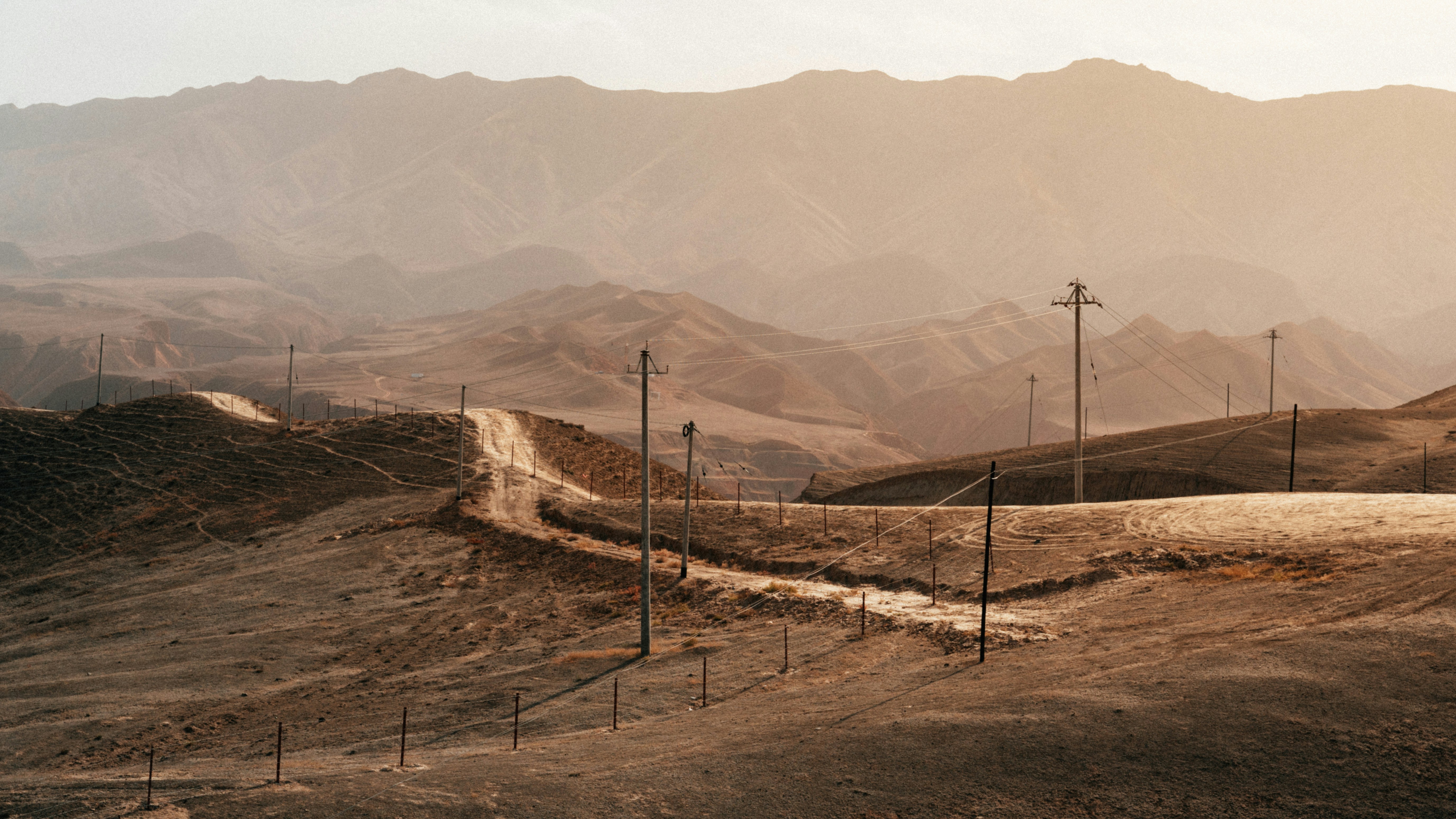 Dusk Roadline: A Desert Fence Tracing Light Across Dunes