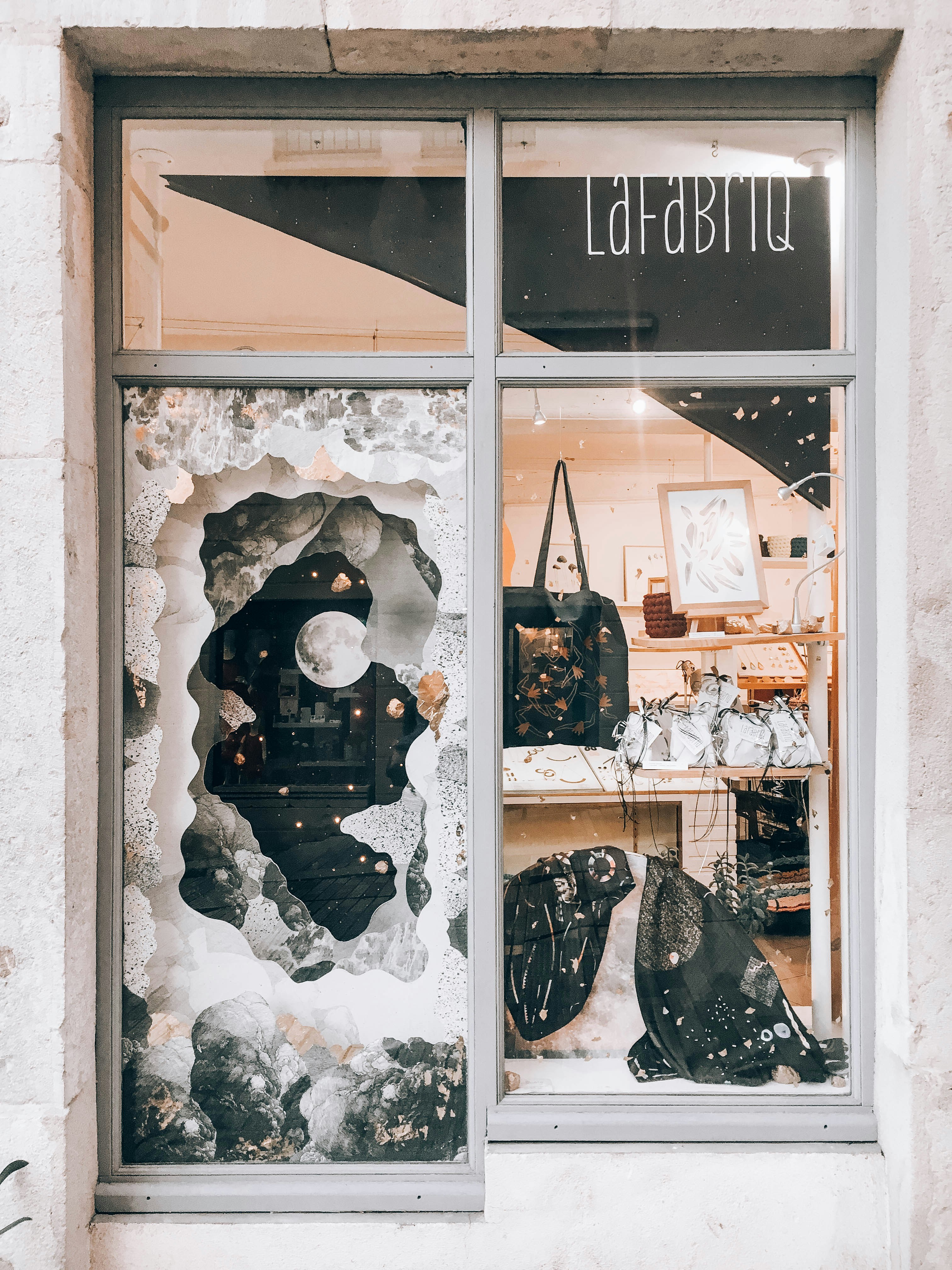 Artistic window display featuring a blend of abstract patterns and artistic merchandise, creating an inviting storefront atmosphere.