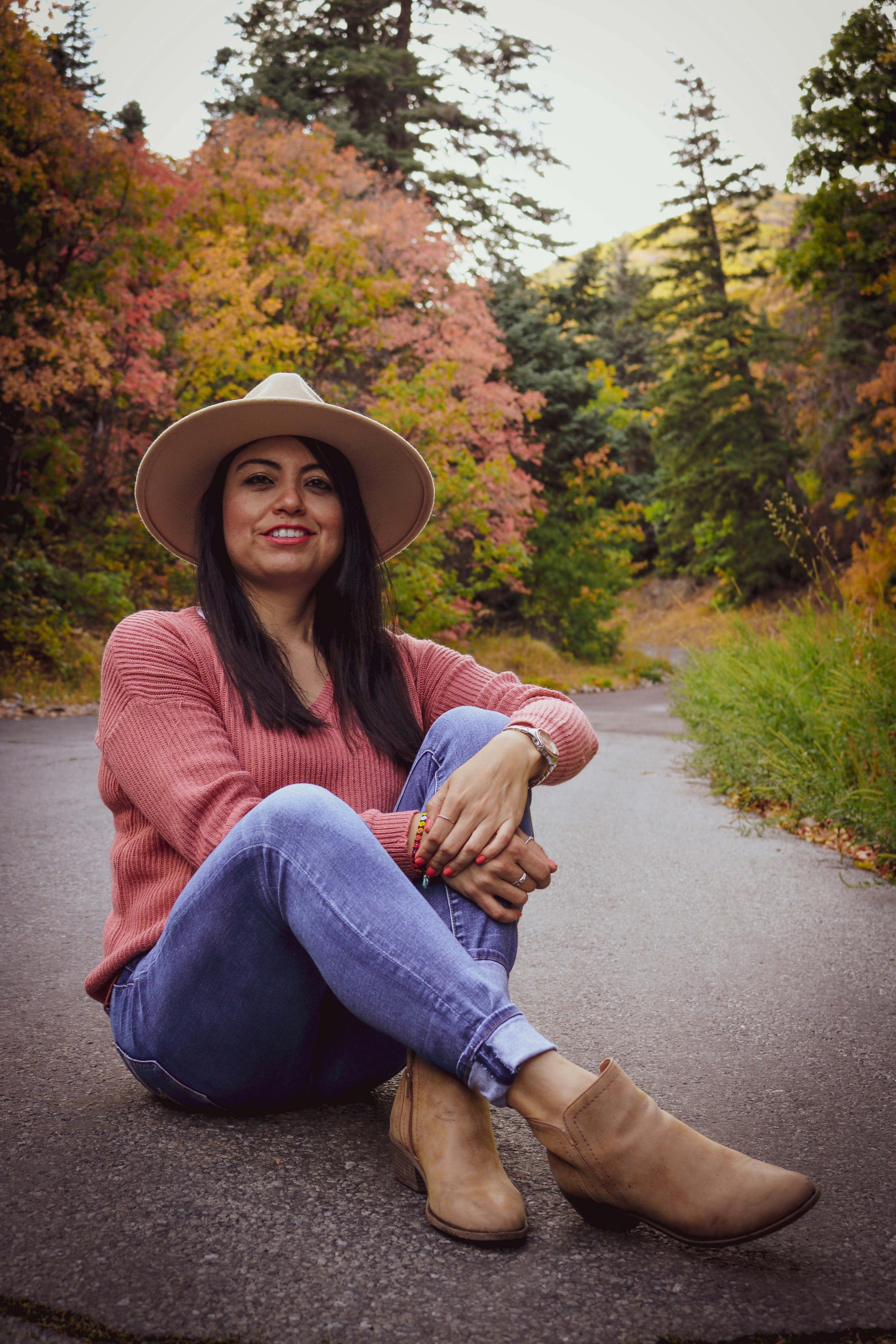 Autumn Quiet: A Woman in a Pink Knit Sitting Amid Fall Road Patch