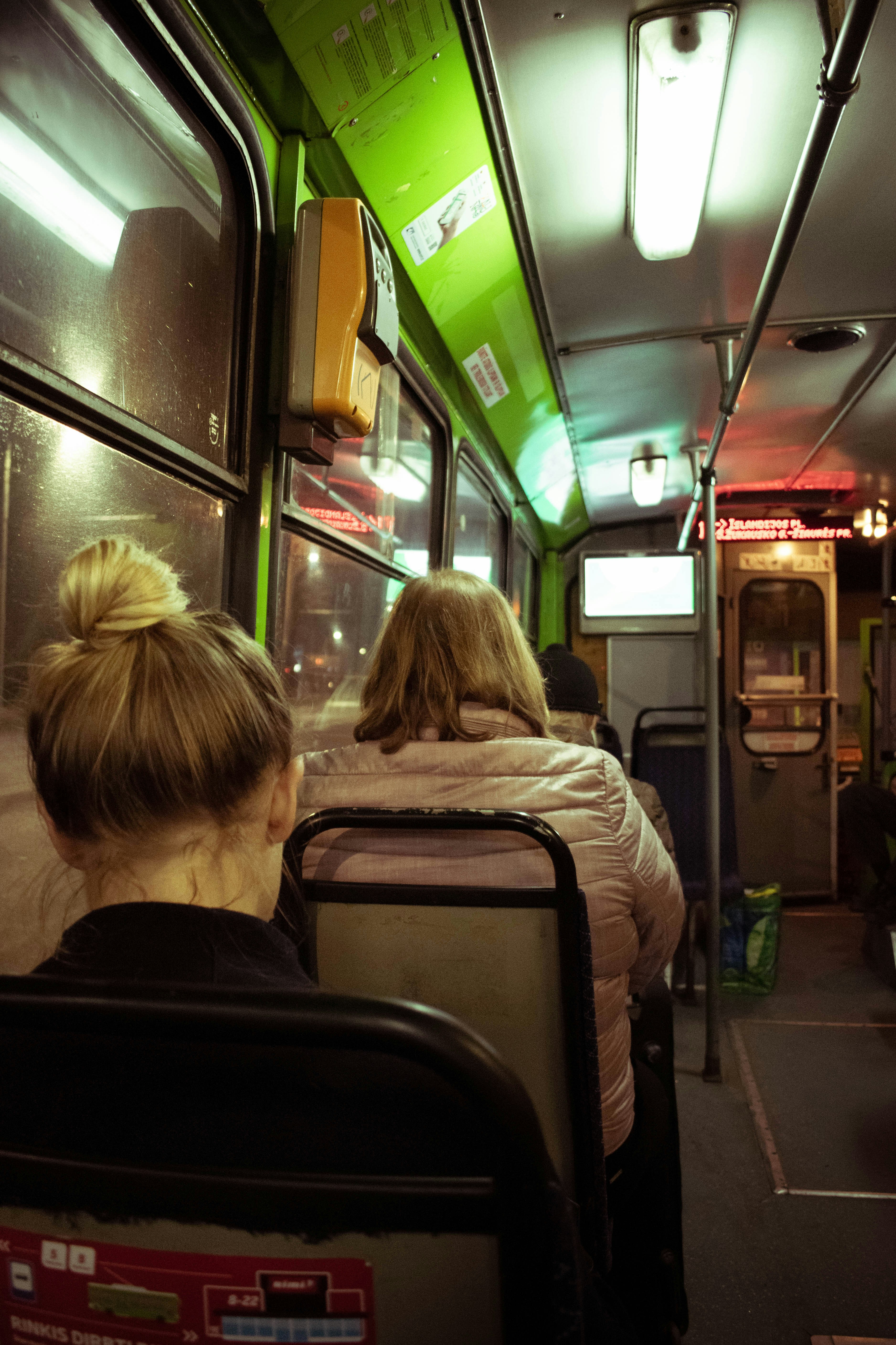 People sitting in a trolleybus, going back home in the evening, tired after work.