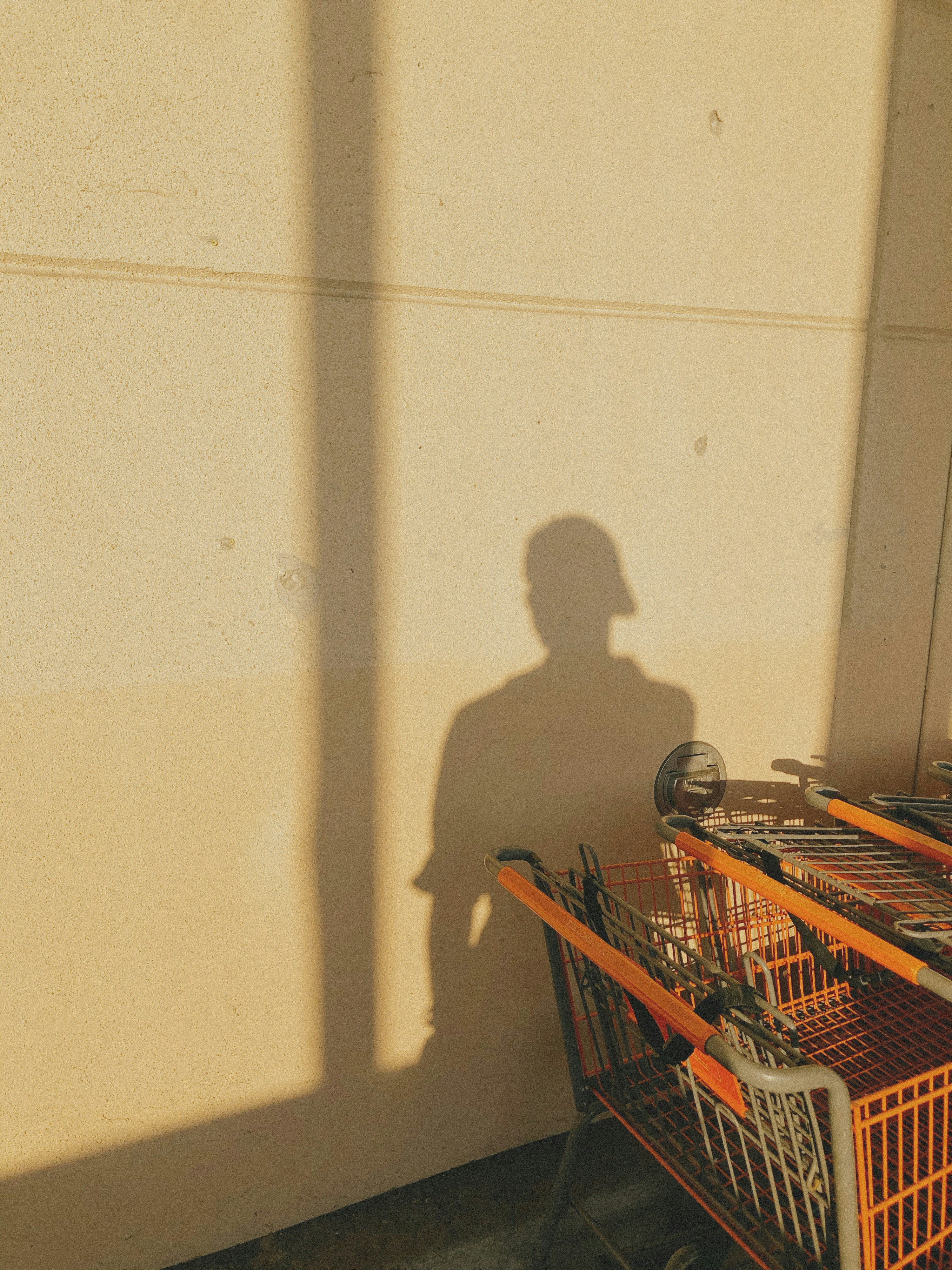 Shadowed Figure and Shopping Carts: A Quiet Ground-Level Still