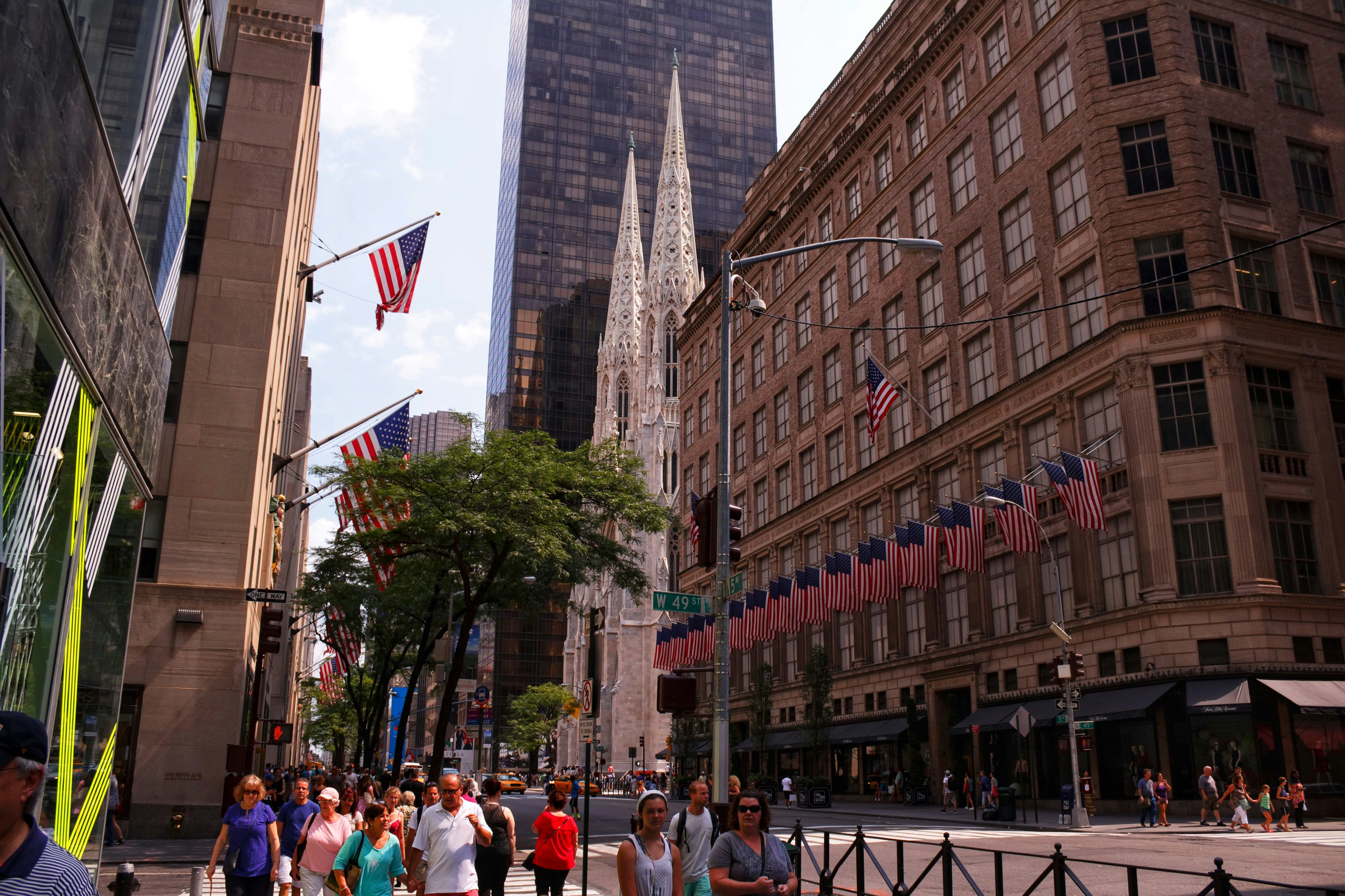 City Pulse: Midday Pedestrians Beneath Flag-Festooned Facades