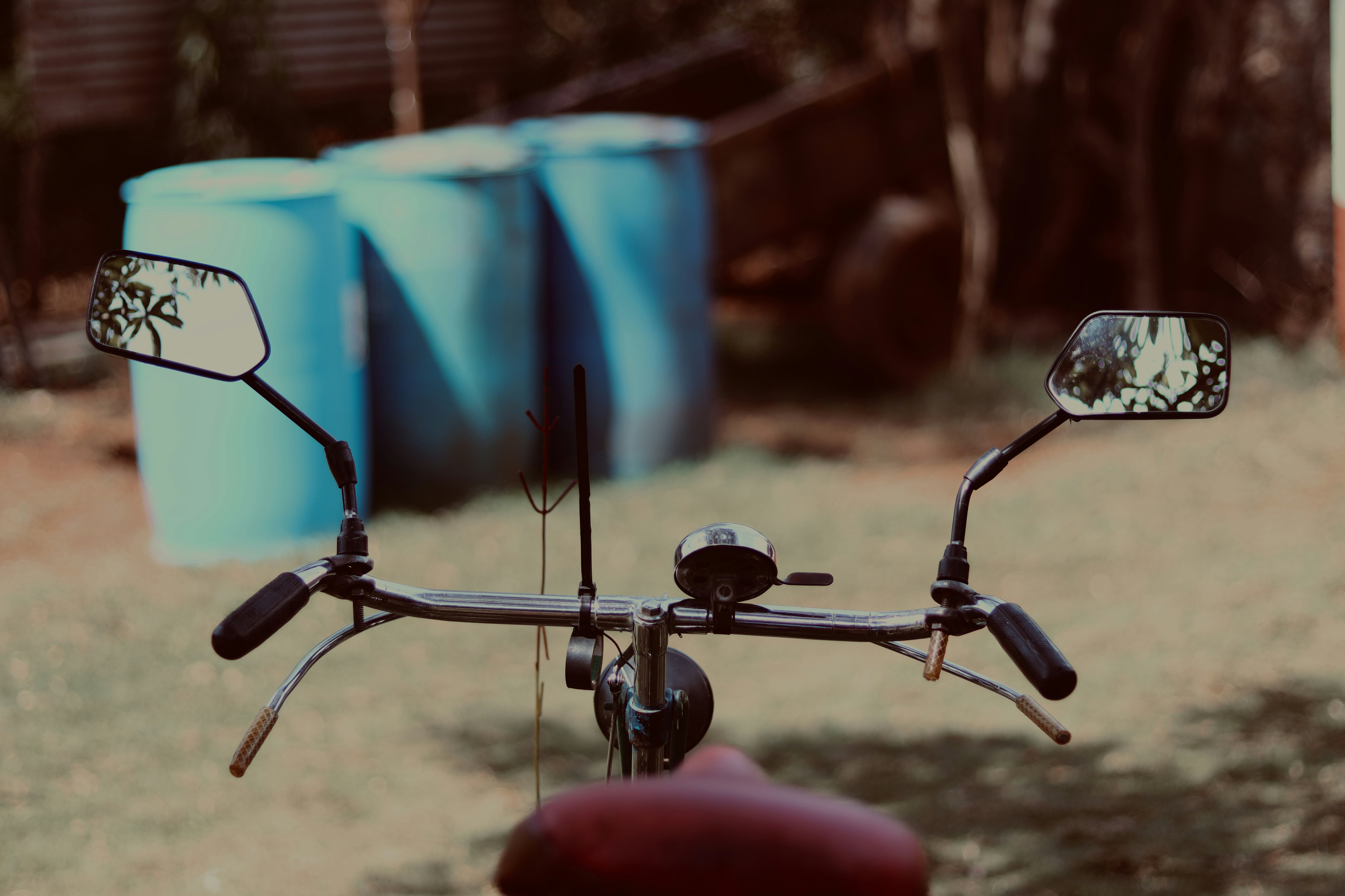 Front-Seat Gaze: Handlebars Framed by a Yard of Blue Drums
