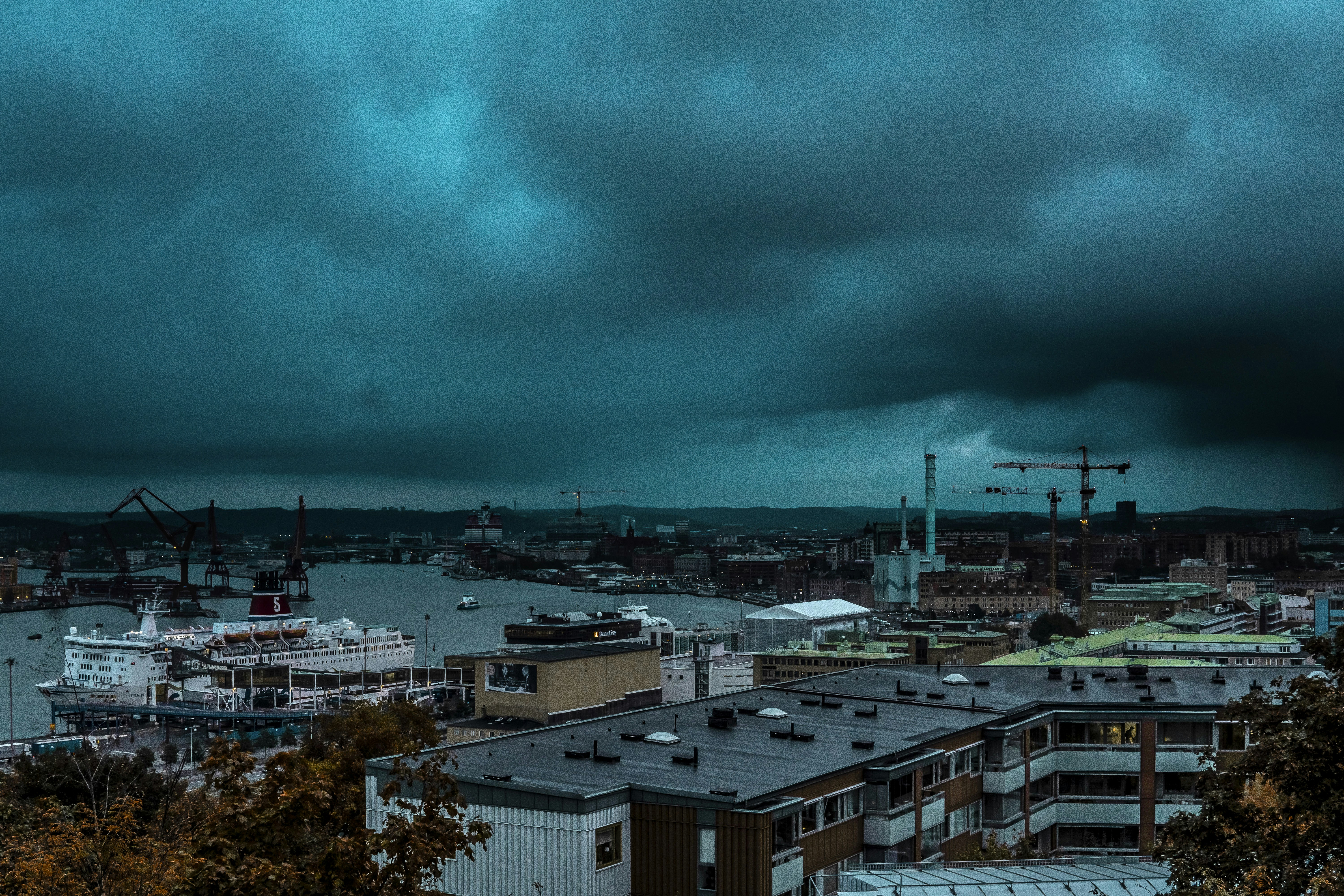 Cloudy evening view over Majorna and the harbor from Masthuggskyrkan in Gothenburg, Sweden, with dramatic skies looming above.