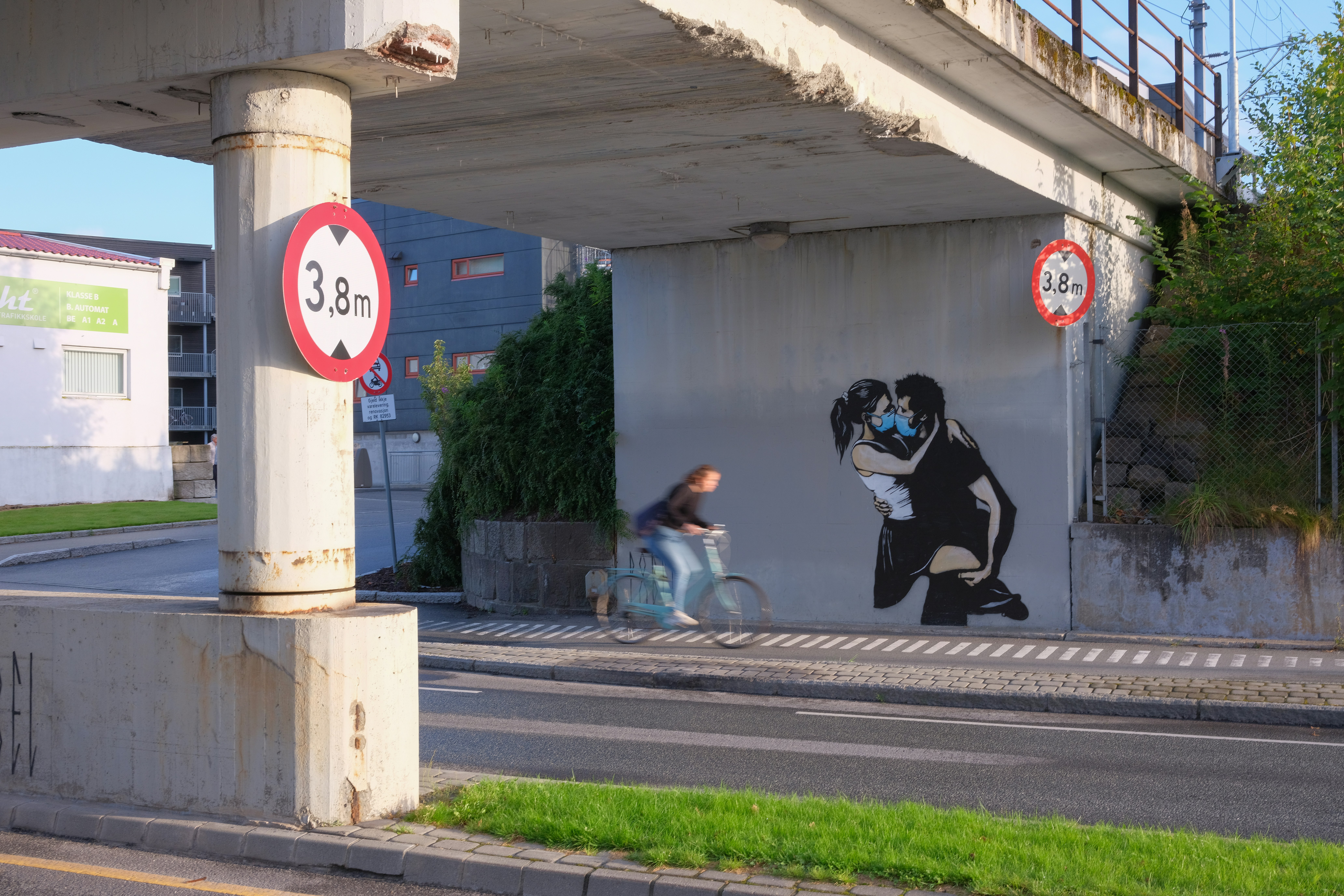 Kiss Beneath the Overpass: a mural anchors motion on a city wall