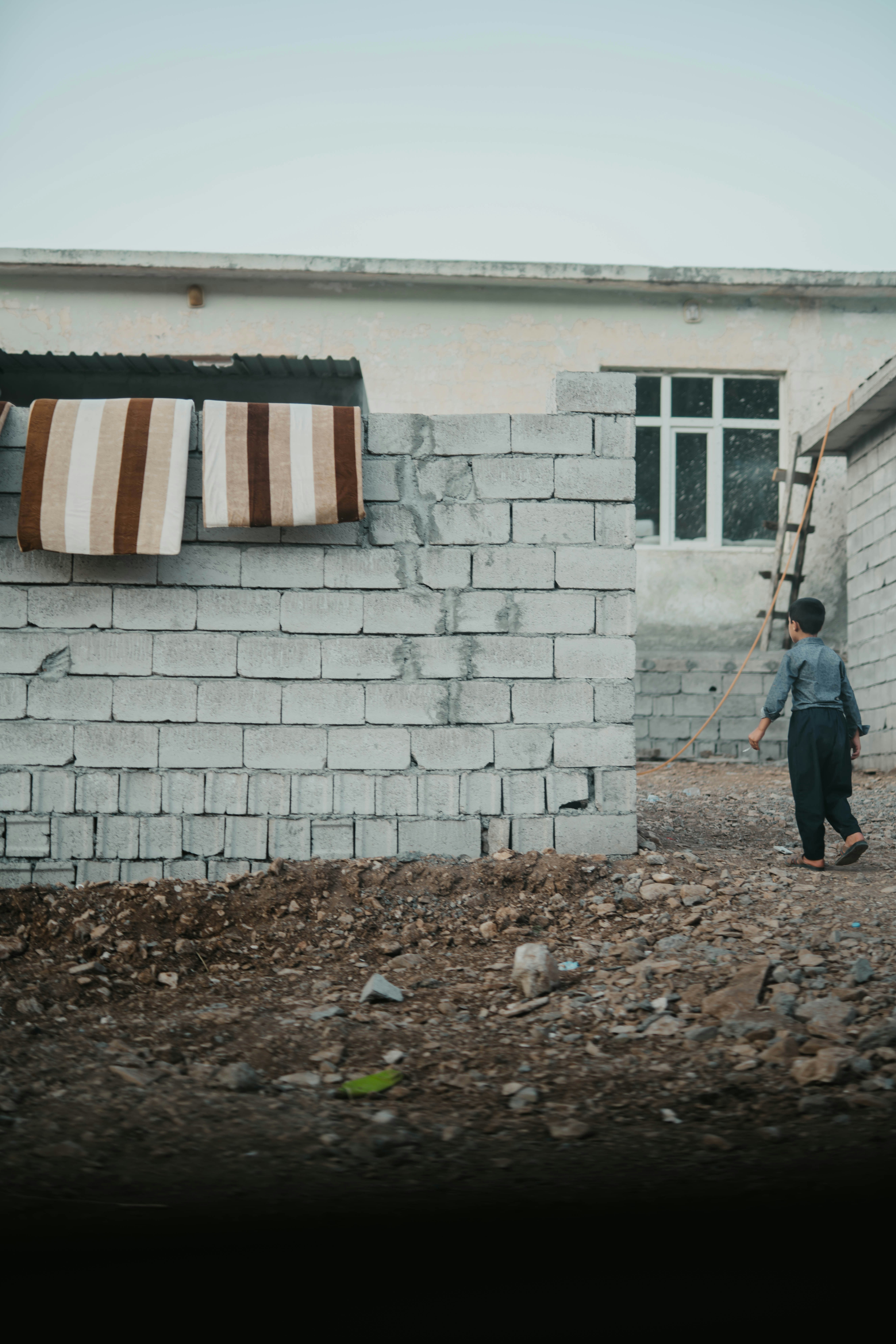 Child by the Wall: A Quiet Moment Between Building Blocks