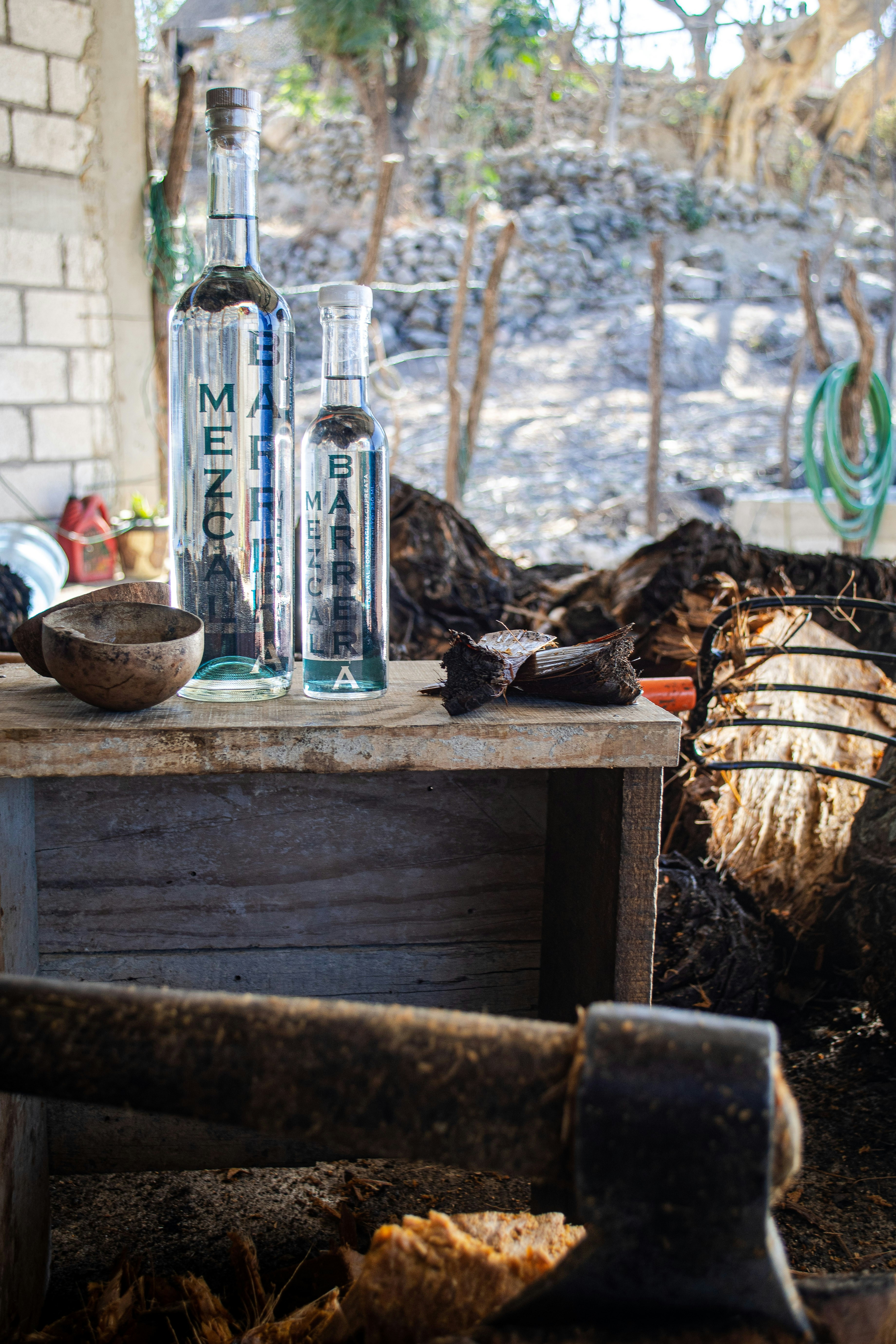 Roasted agave and mezcal bottles.
Photo by Hector López | clear glass bottle on brown wooden table