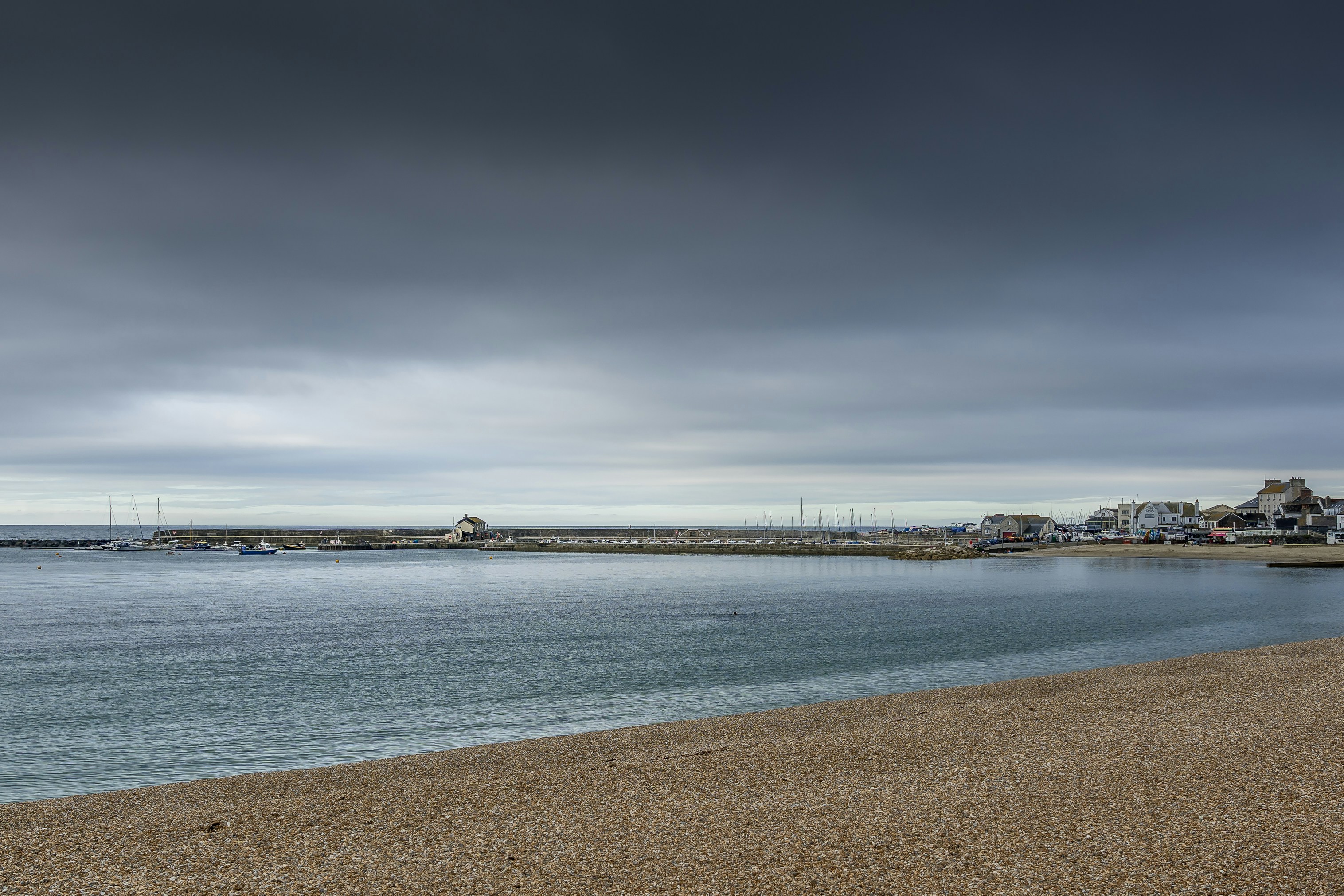 Tranquil Shores of Lyme Regis Under Moody Skies