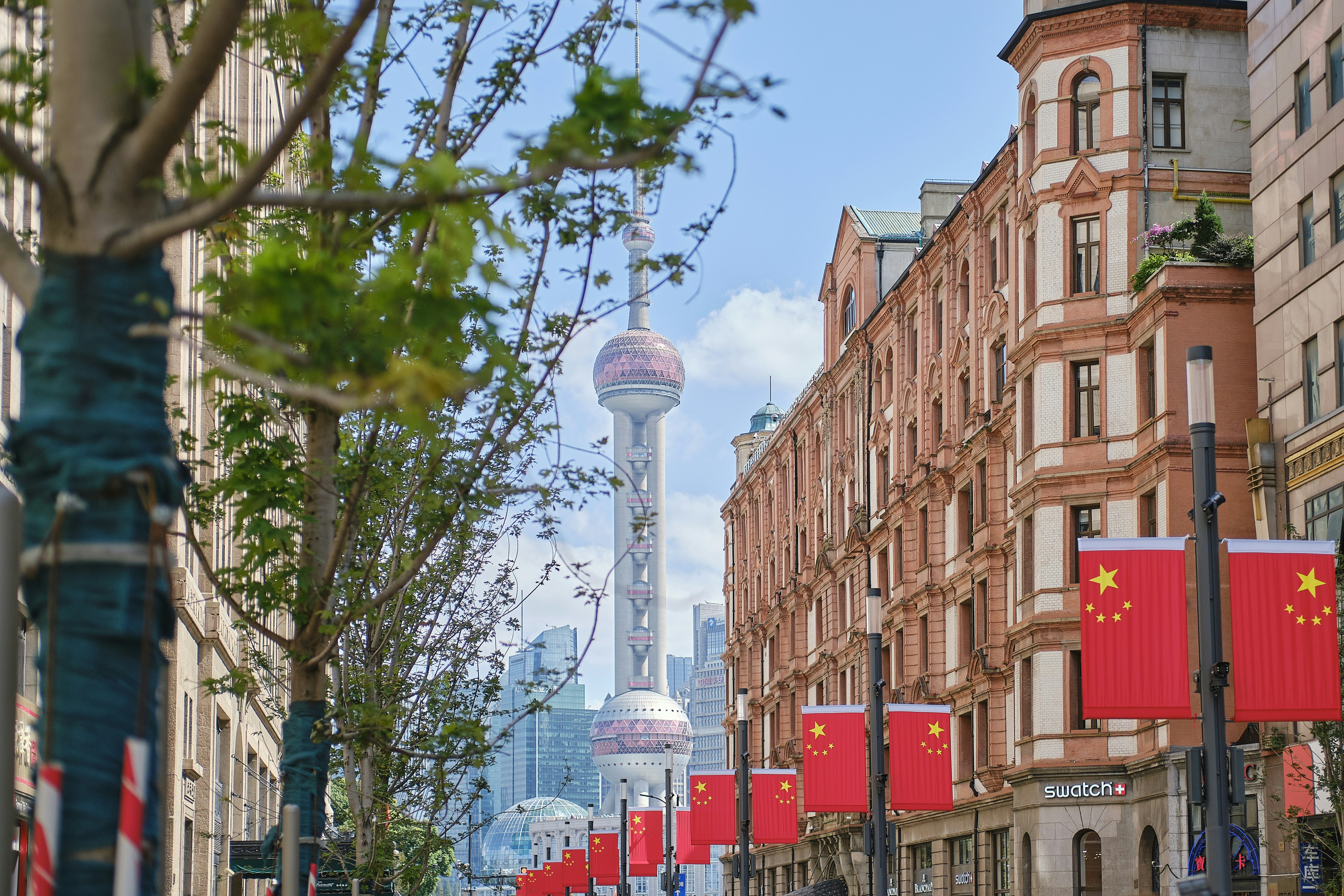 Street Corridor to the Sky: Red Flags, Red Buoys, and a Towering Cityscape