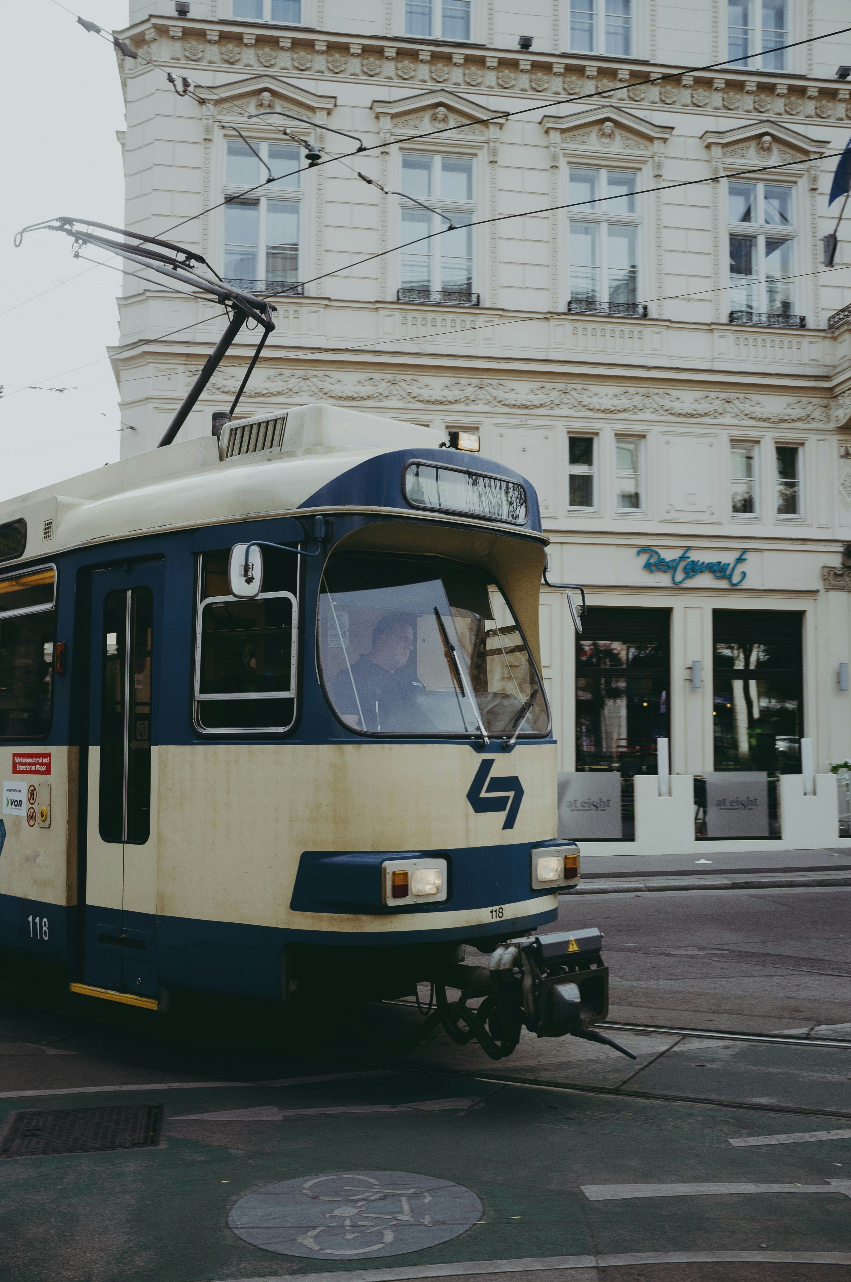 Tram navigating through a bustling urban street, showcasing the blend of transportation and architecture. The scene captures the essence of daily city life.