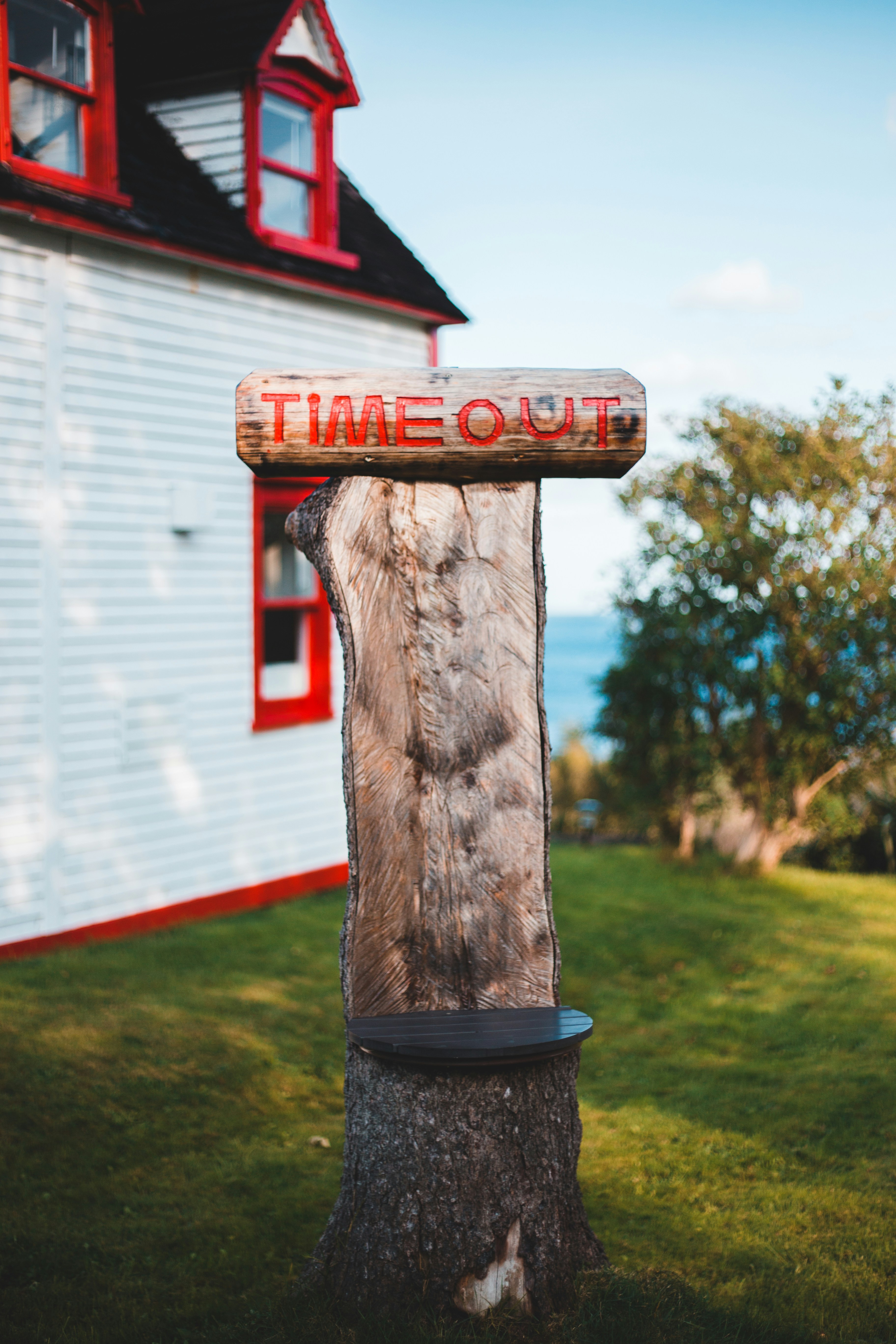 Weathered Time-Out Marker Stands Beside a Lakeside Cottage