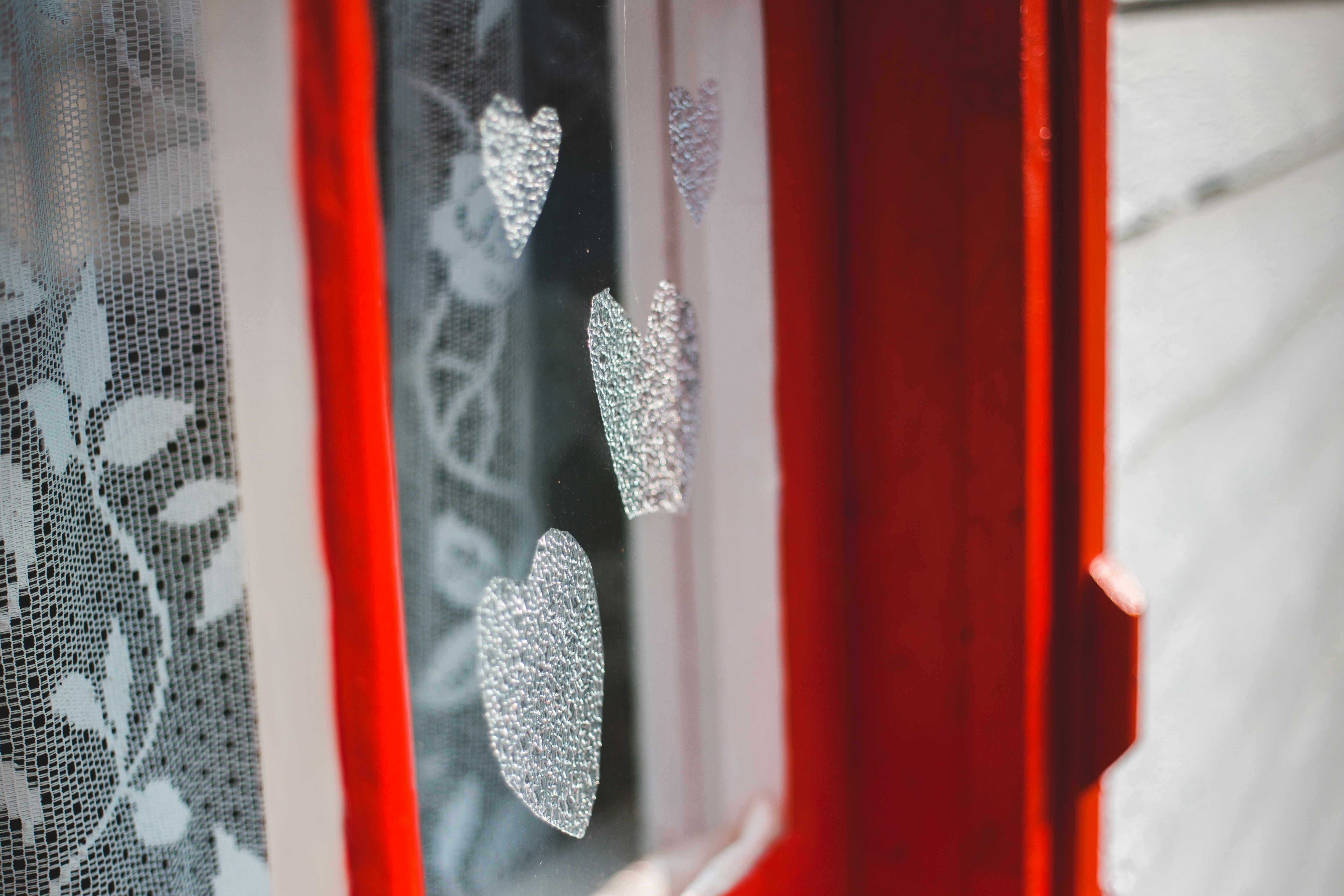 Red Frame, Frosted Hearts: A Close Window Portrait