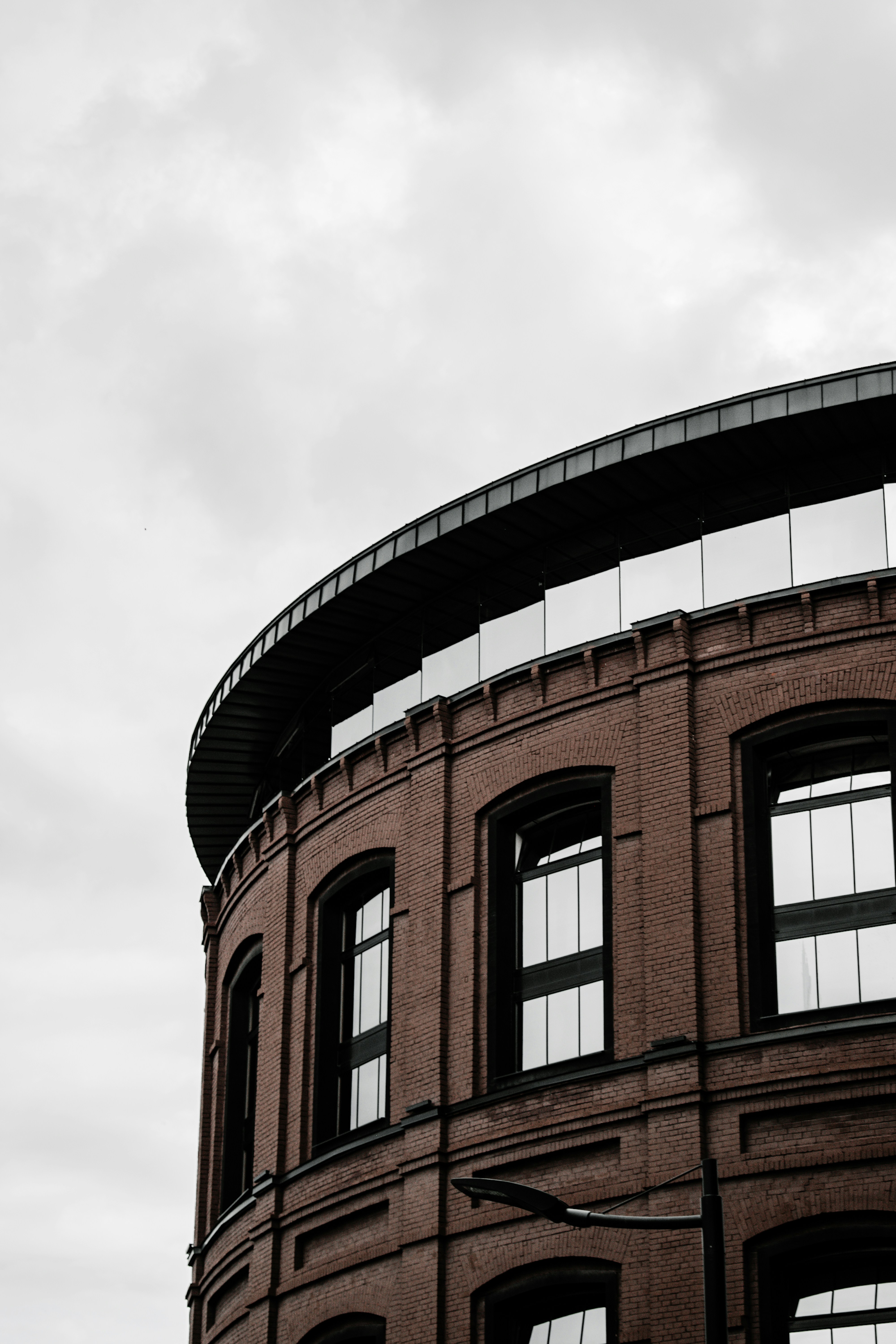 Arc of Brick: A Circular Facade Lost in Overcast Light