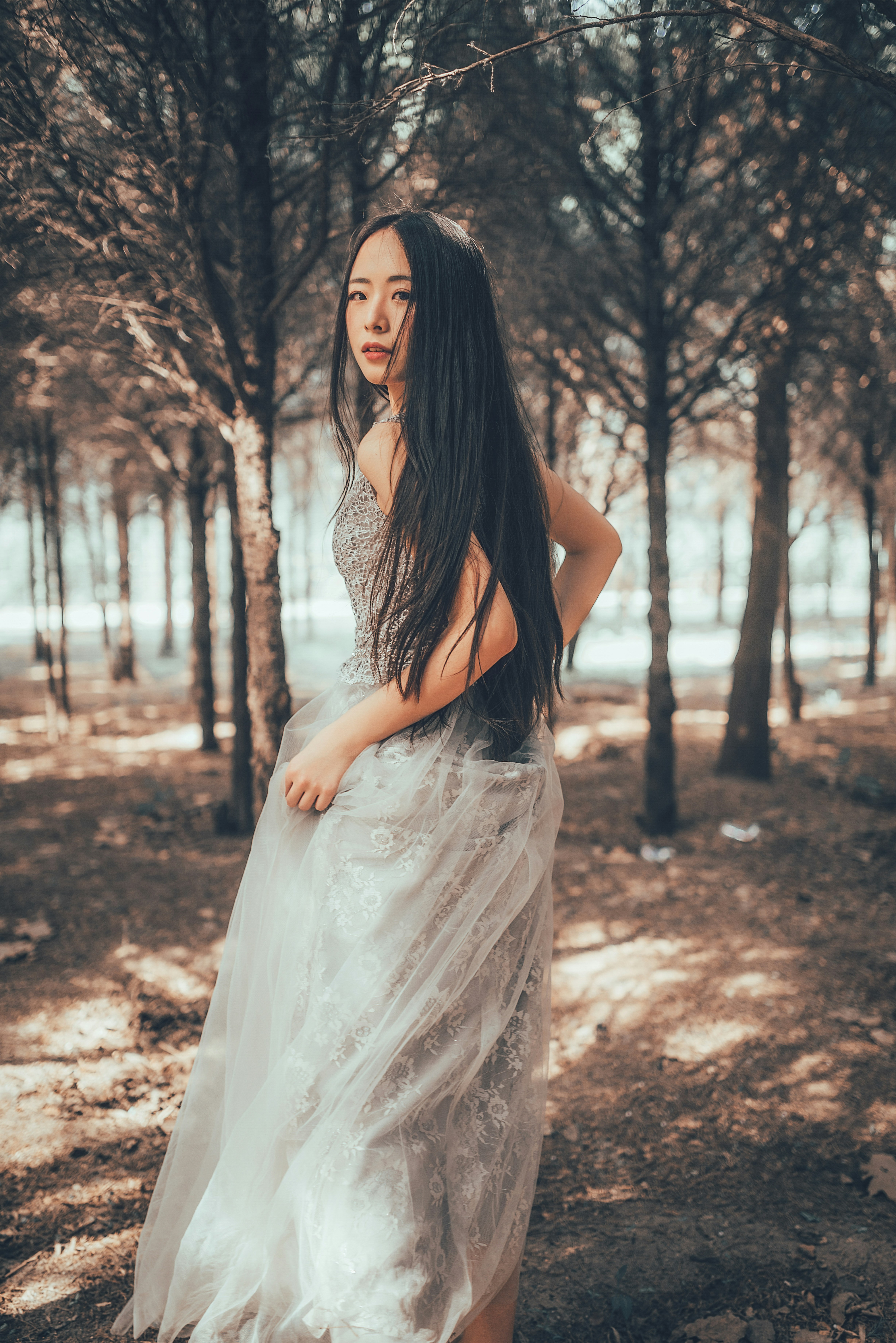 Foto Mujer en vestido blanco de pie en suelo marrón durante el día – Imagen Gris gratis en Unsplash