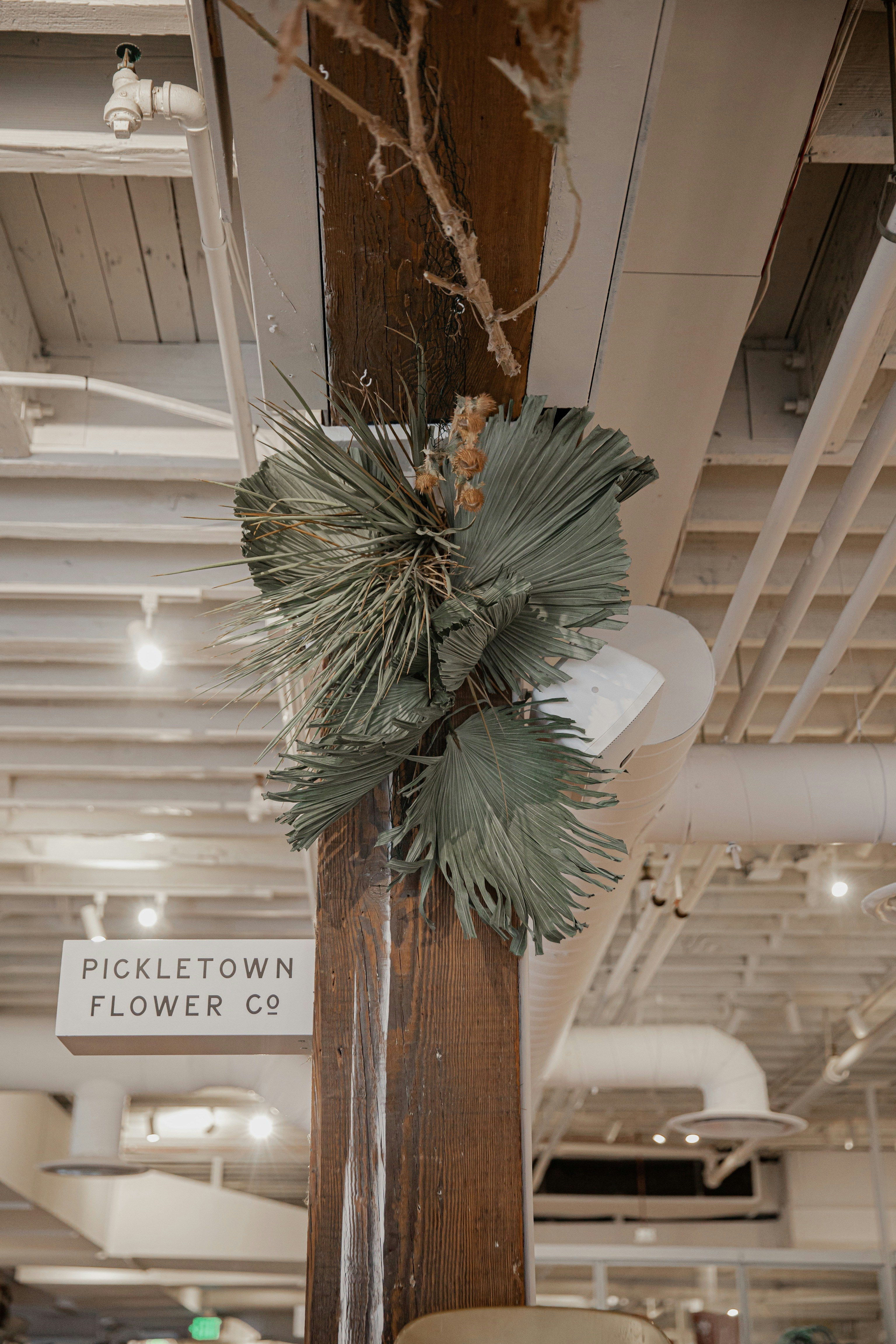 Palm Fronds on a Timber Pillar in Pickletown Flower Co.'s Industrial-Floral Corner