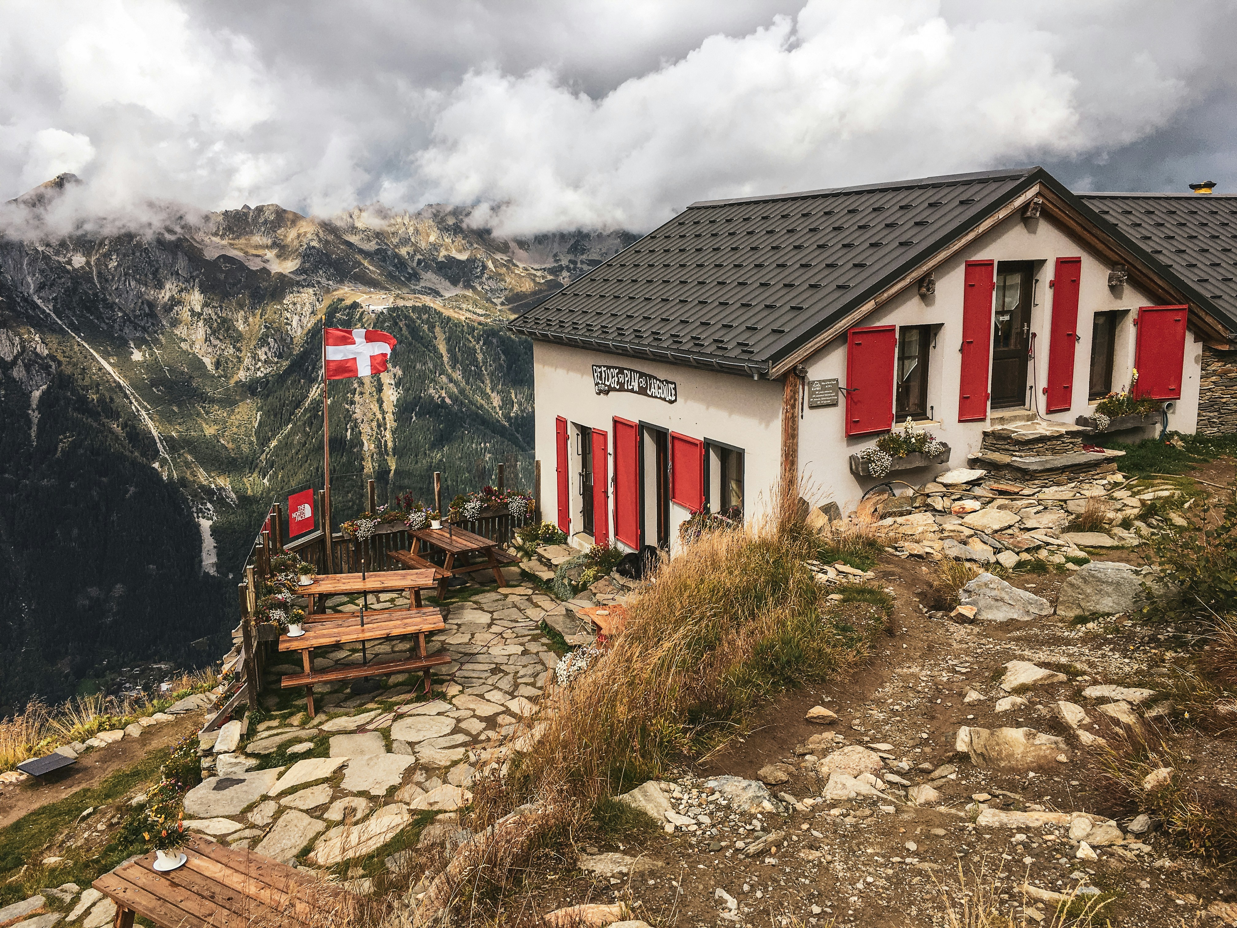 Alpine Refuge with Red Shuttered Chalet on a Cliffside Trail
