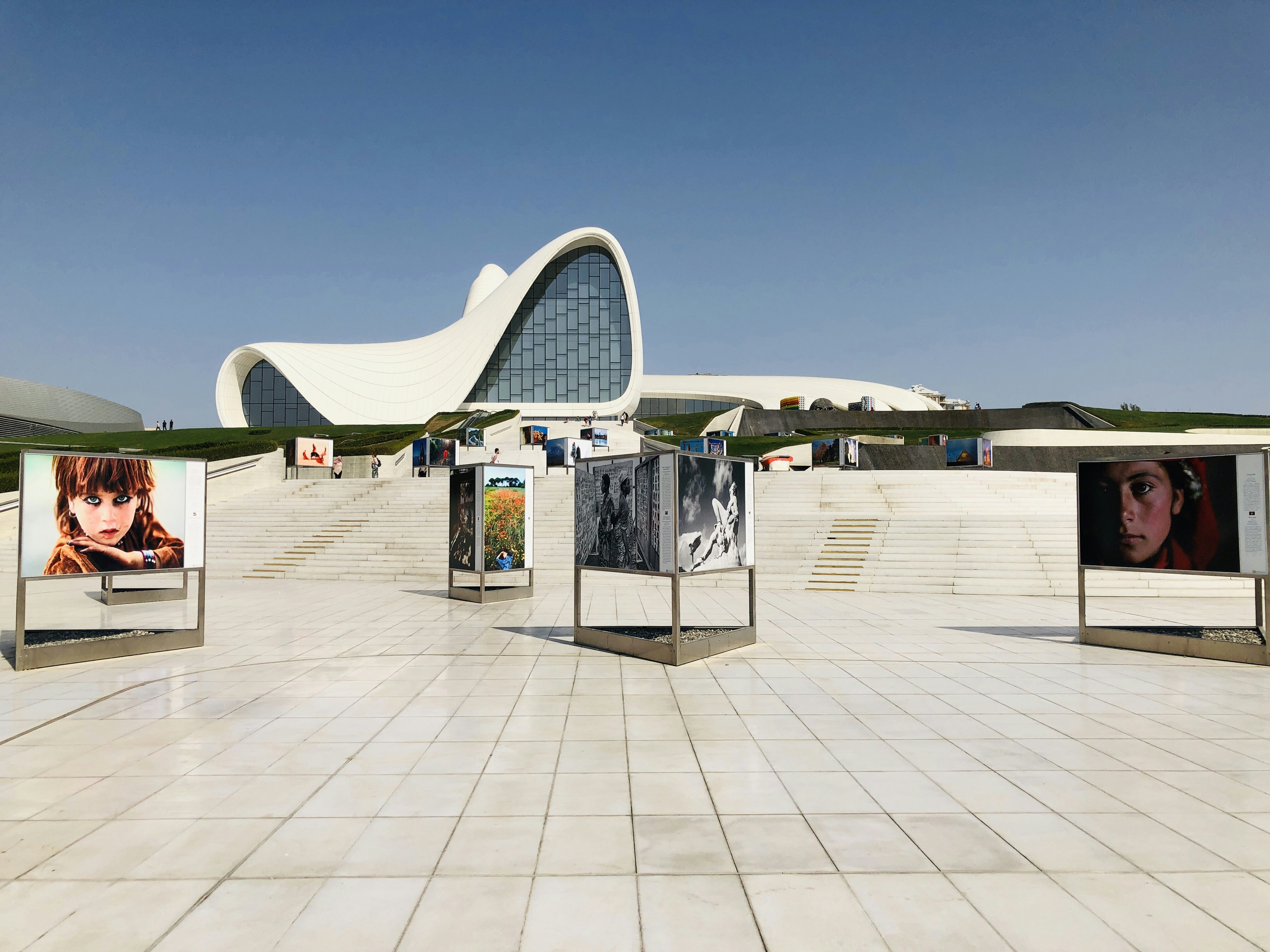 People walking on white concrete floor under blue sky during daytime ...