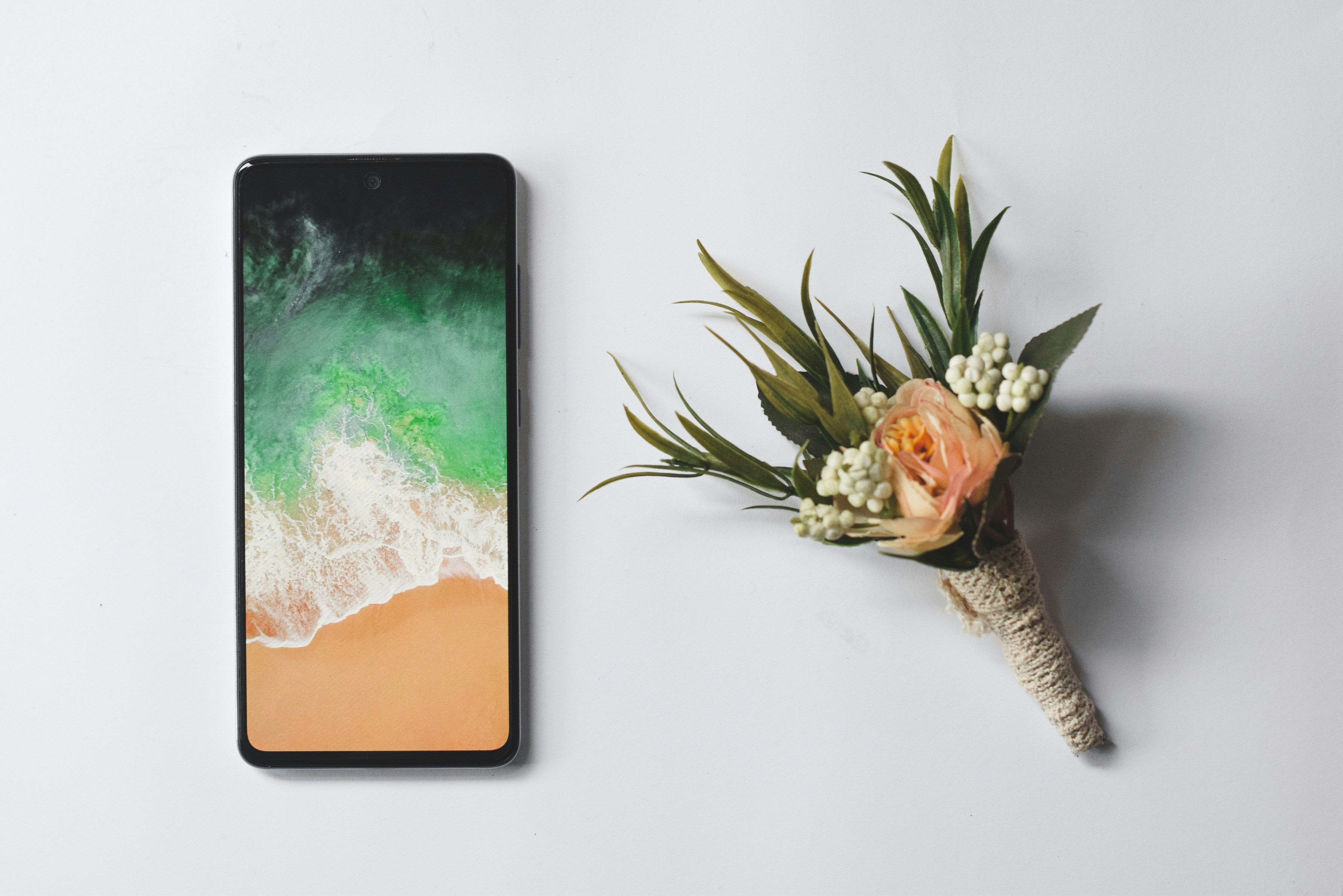 Neon Edge: Phone and Floral Boutonniere on a Minimal White Surface