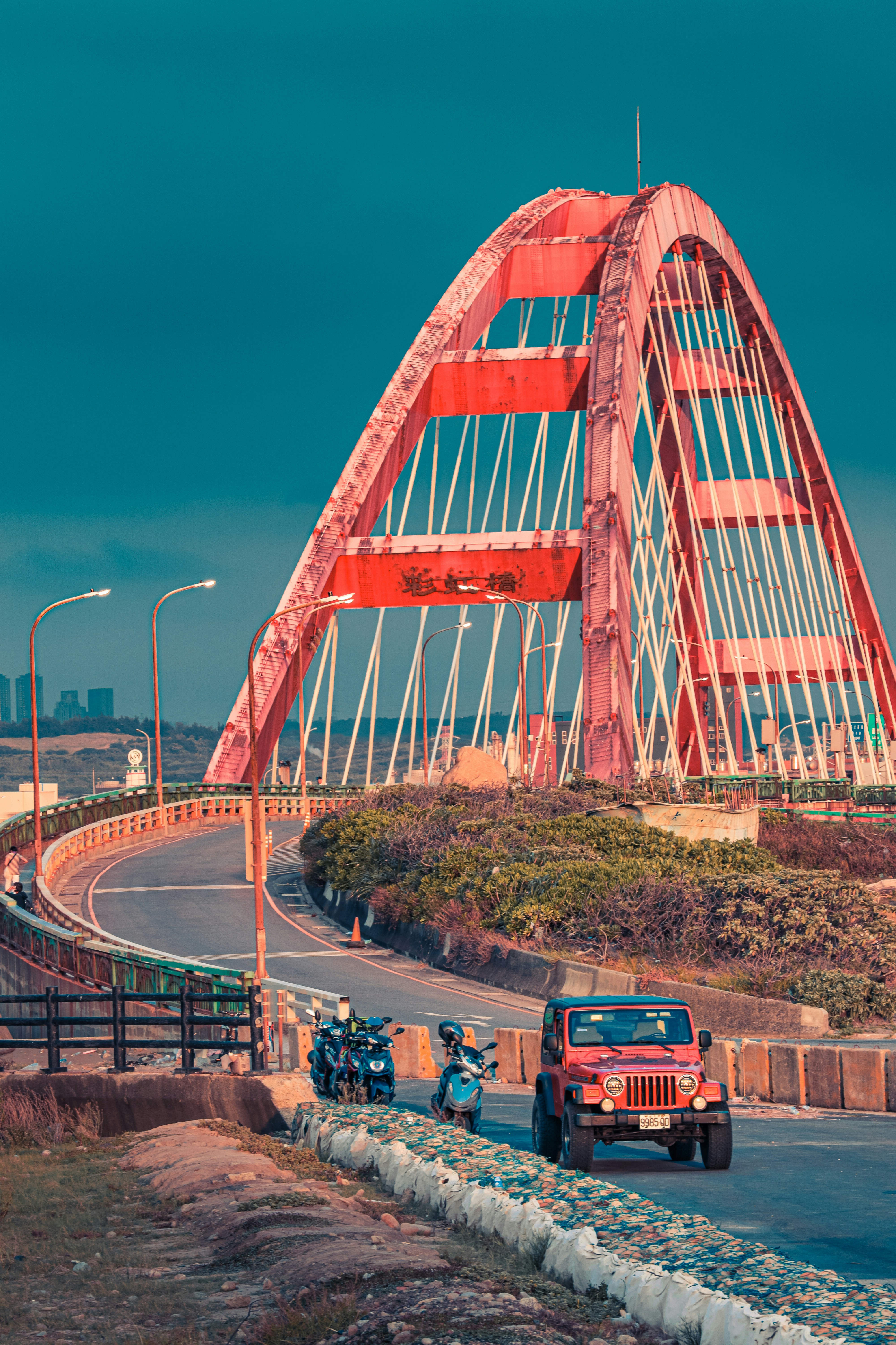 Red Arch Bridge Framed by a Winding Coastal Road