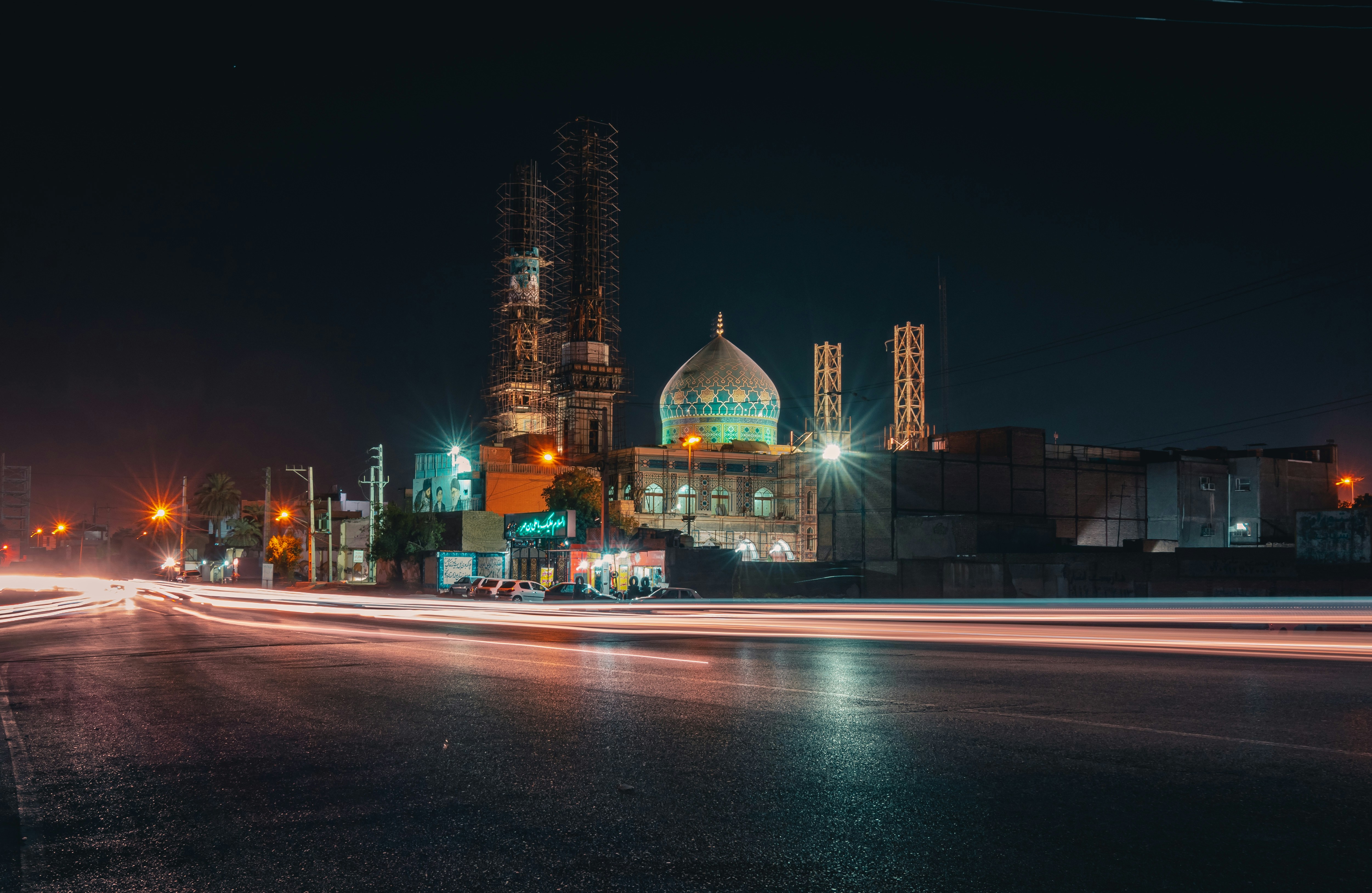 Long exposure of the Ali Ibn Mahziar Shrine with light trails from passing cars at night.