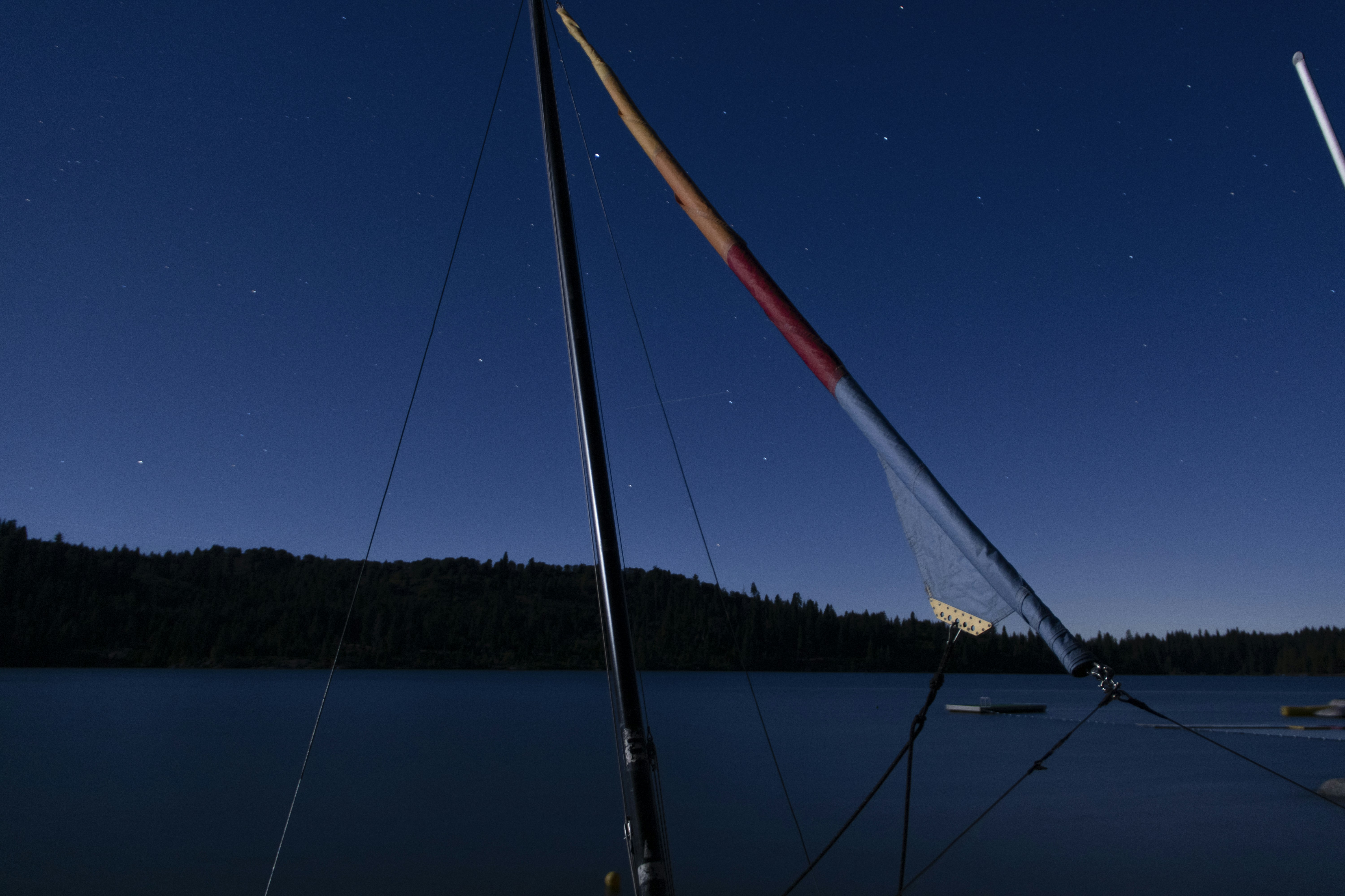 Starry Night Sail: A Slanted Mast Framing a Silent Lake