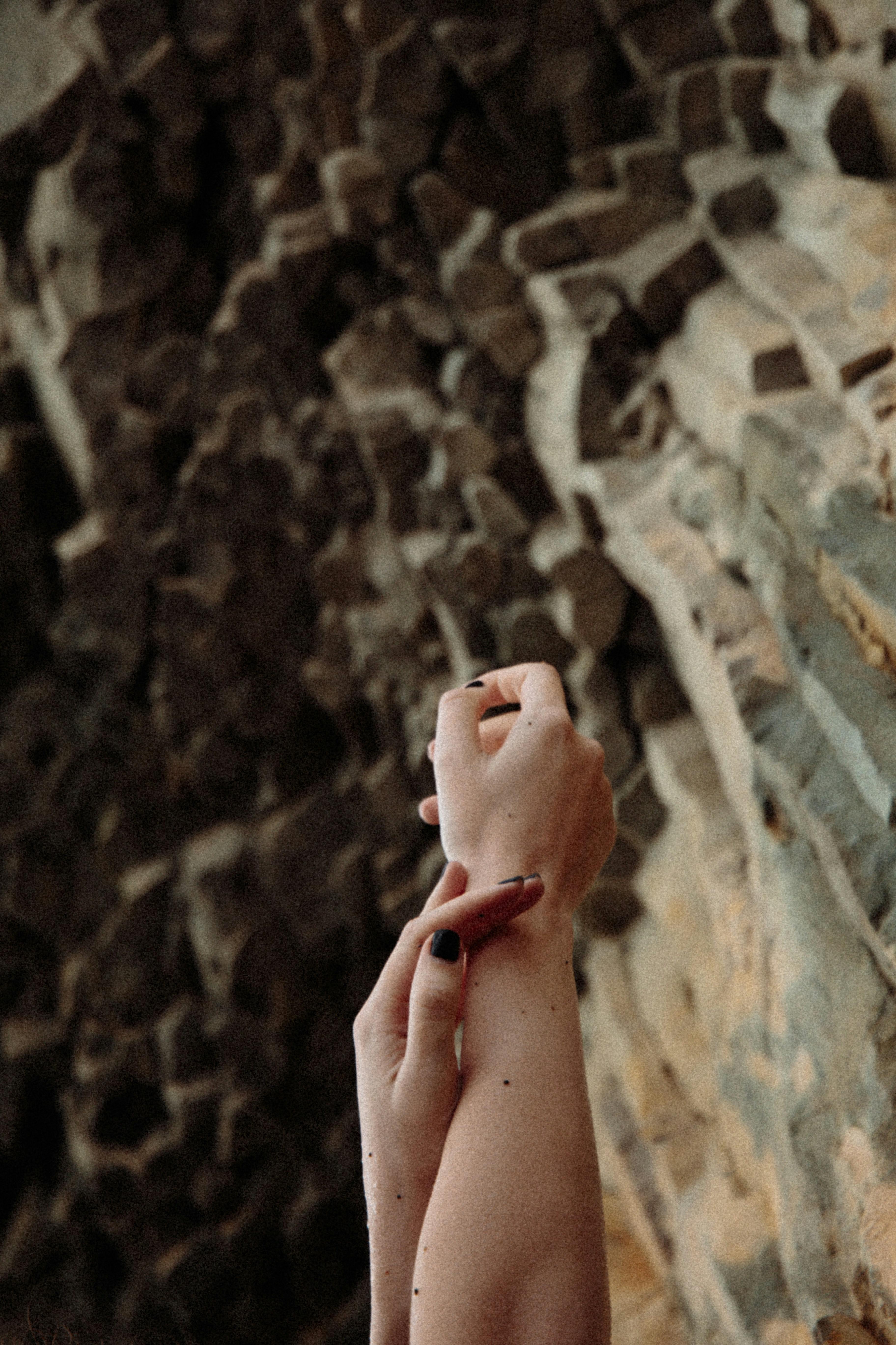 Intertwined Hands Against a Stone Corridor