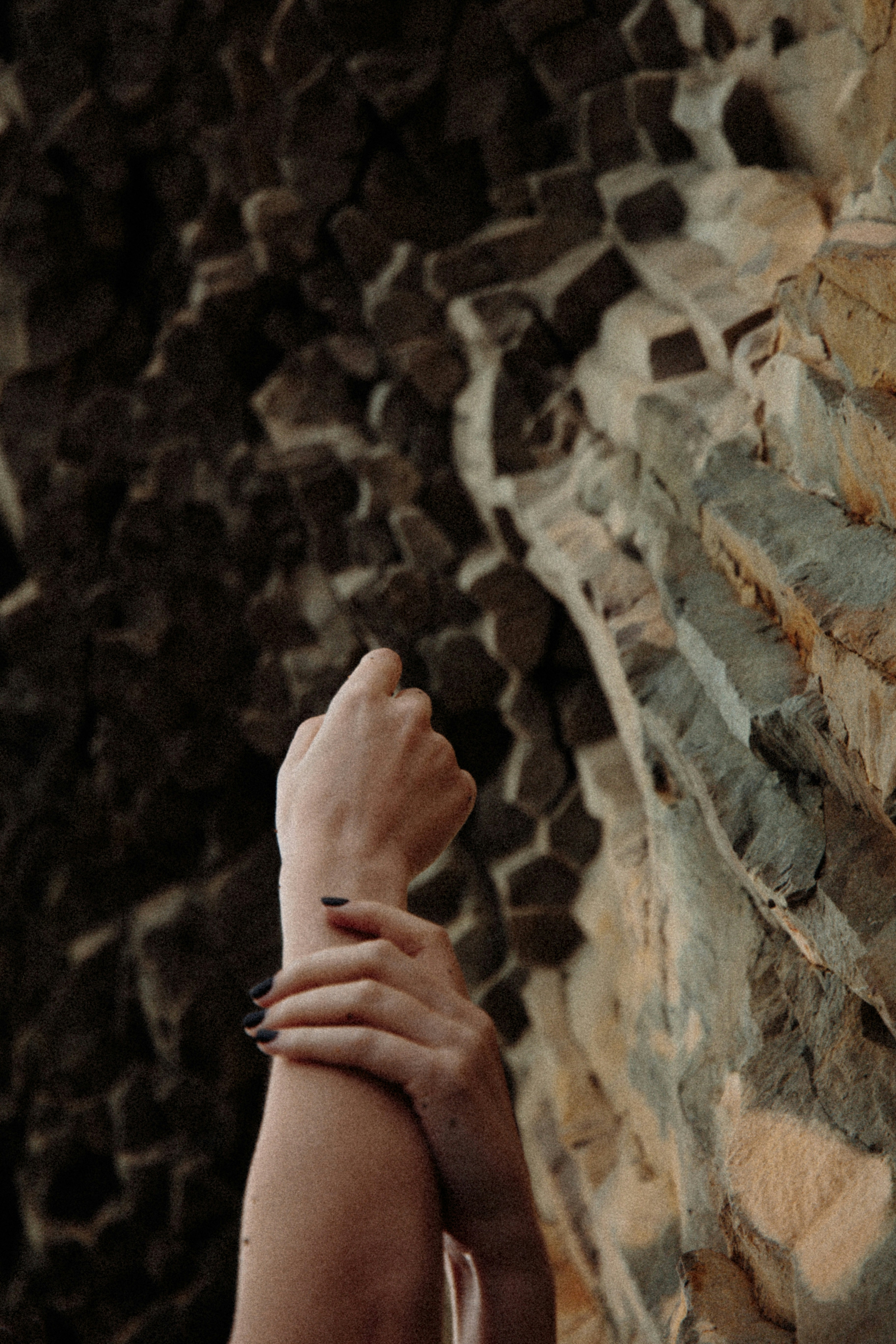 Hands Against Stone: A Quiet Gesture in a Dim Corridor