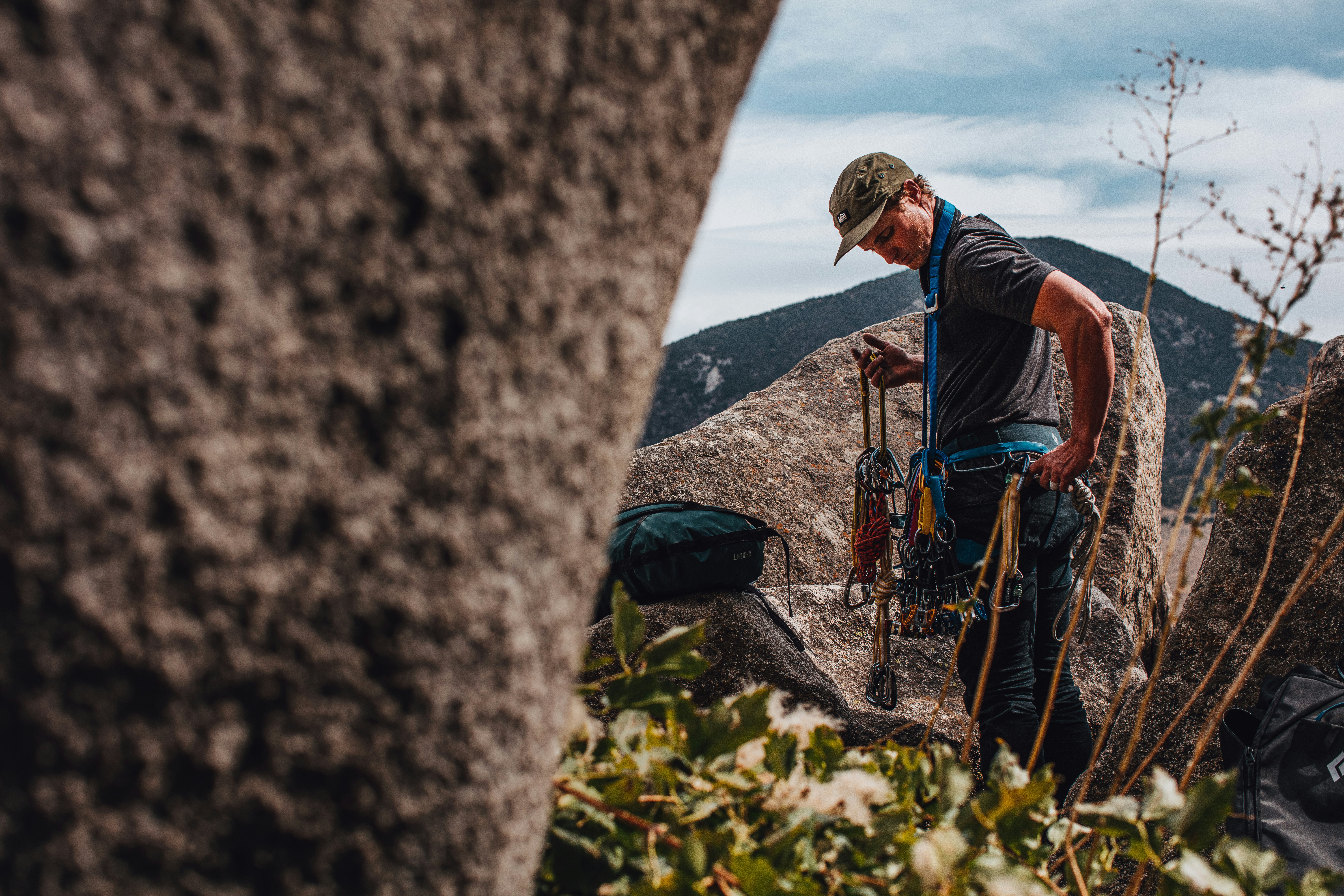 Granite Verge: Climber Tightening Gear on a Wind-Swept Crag