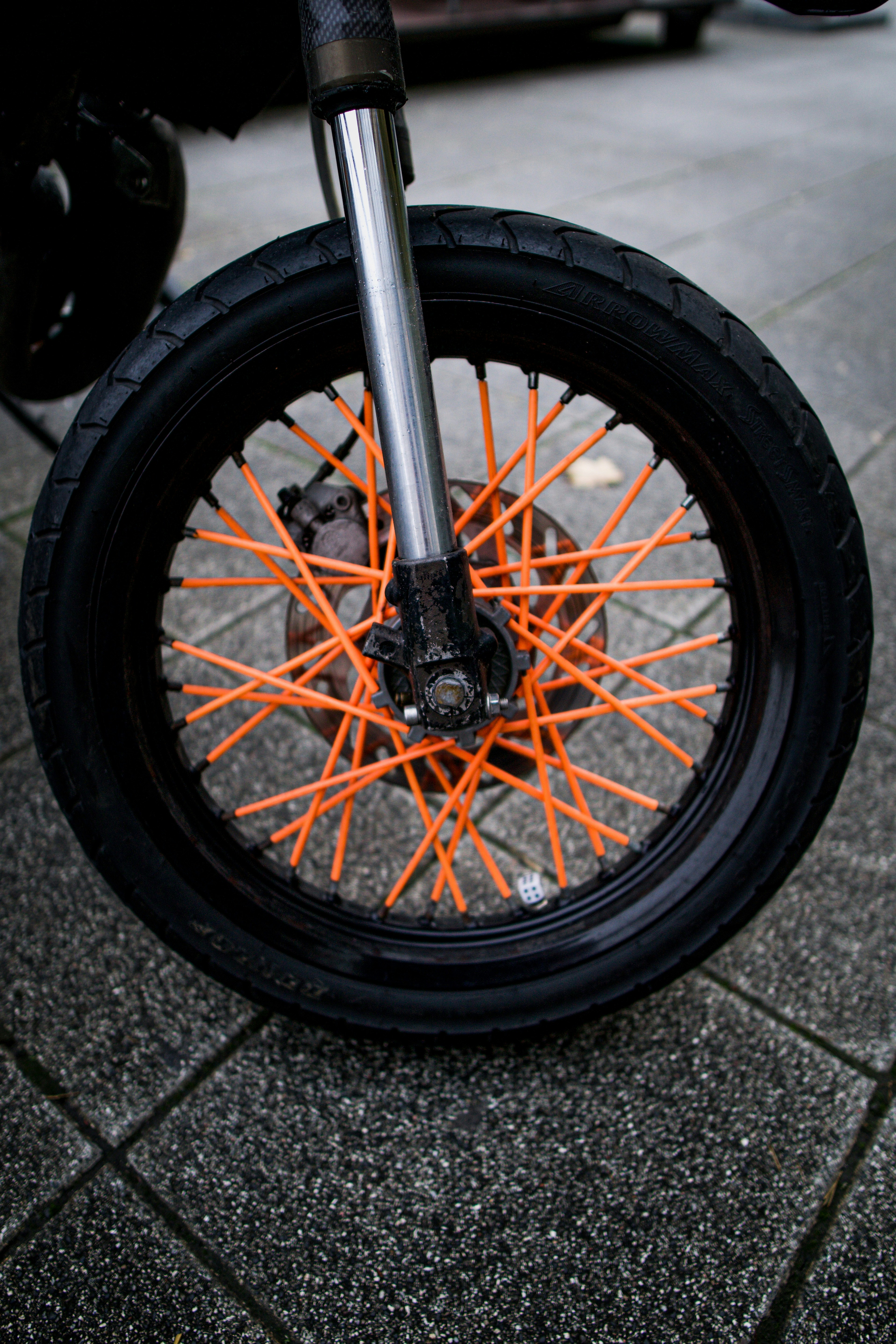 Neon Orange Spokes: A Close-Up of a Motorcycle Wheel