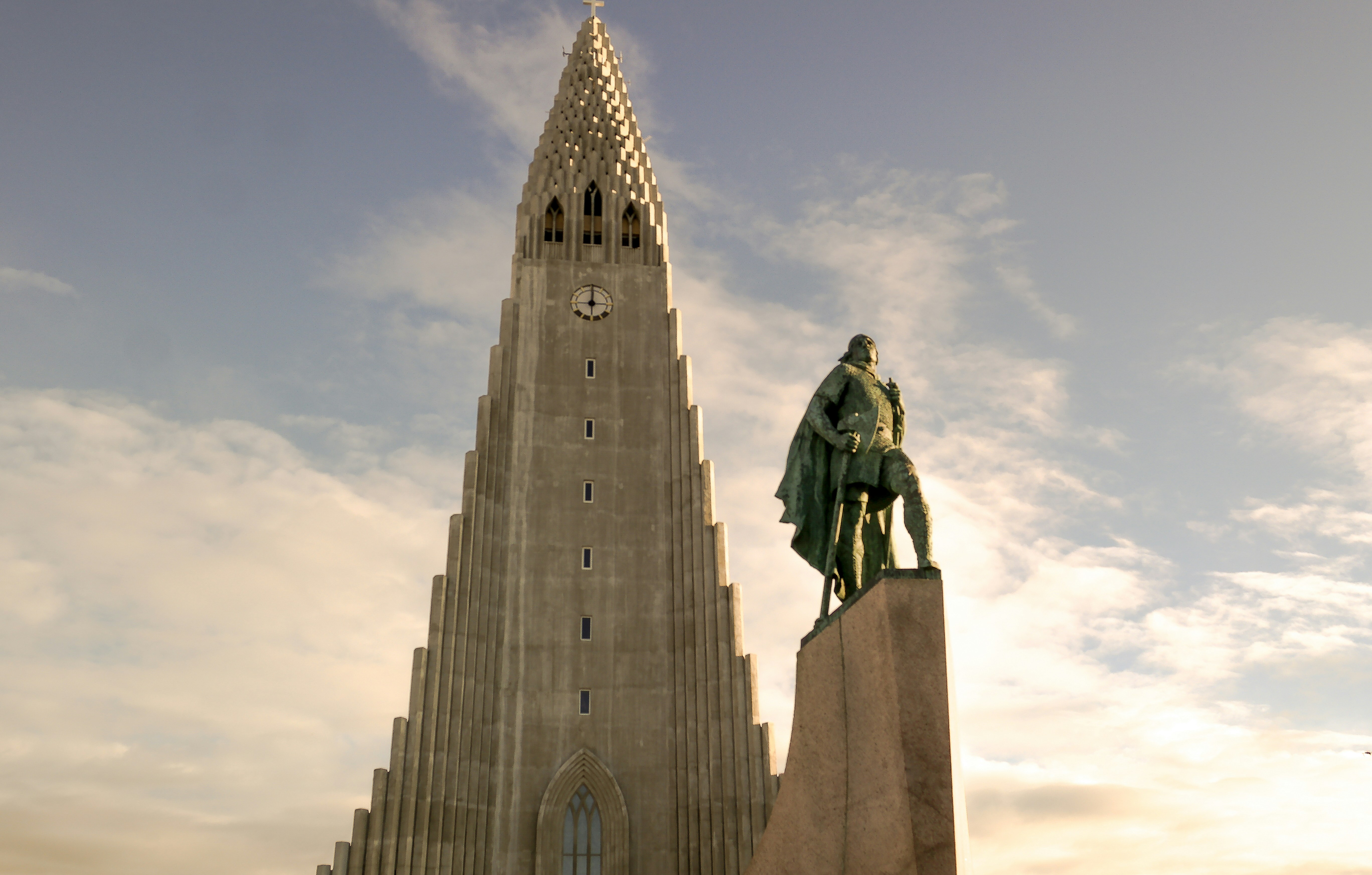 Hallgrímskirkja church tower soaring into a clear sky, with a statue of Leif Erikson in the foreground.